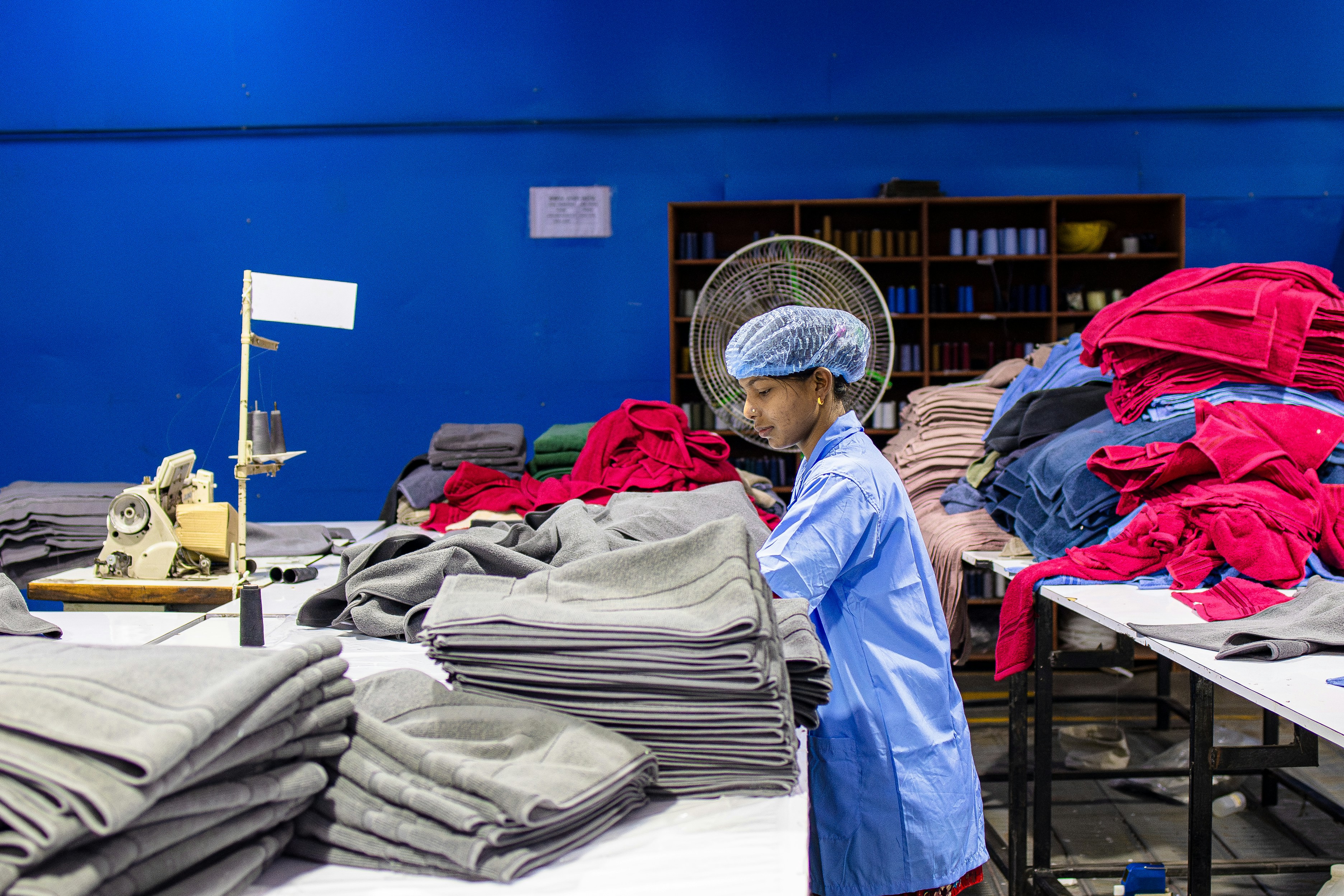 A factory worker inspects finished garments. photo – Free Worker Image ...