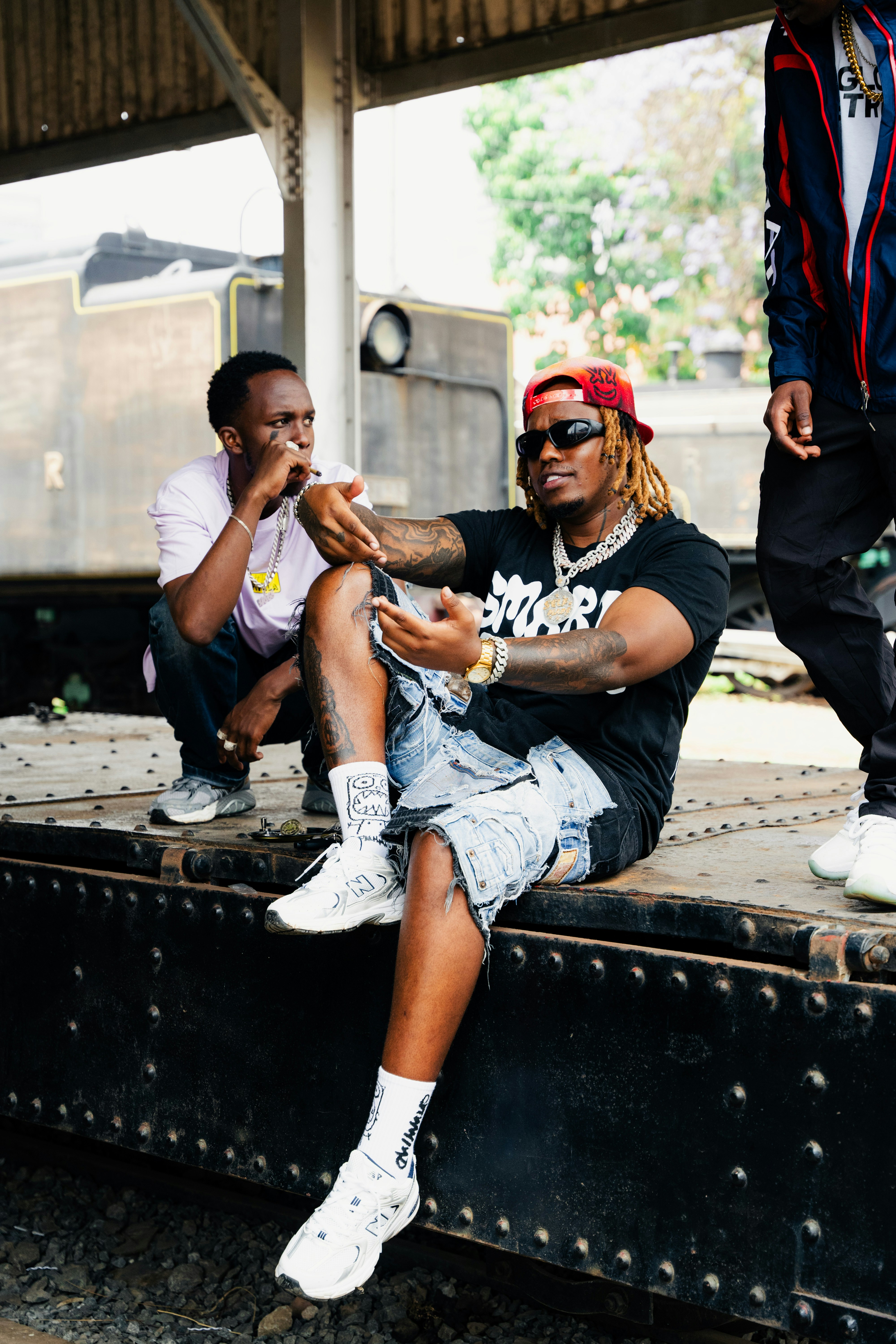Men sit and pose on a train platform. photo – Free Portrait Image on ...