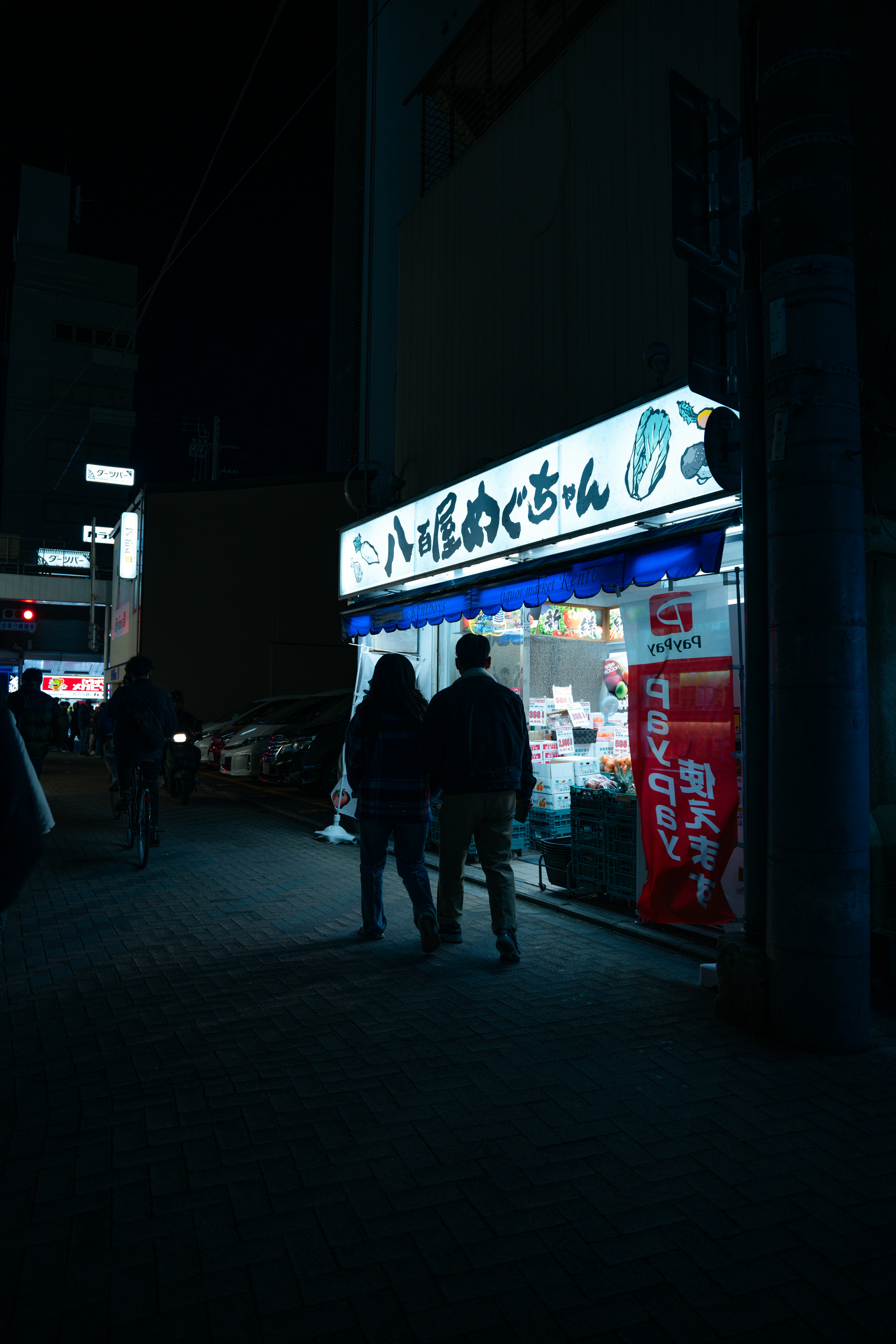 A couple walks past a japanese store at night. photo – Free Japan Image ...