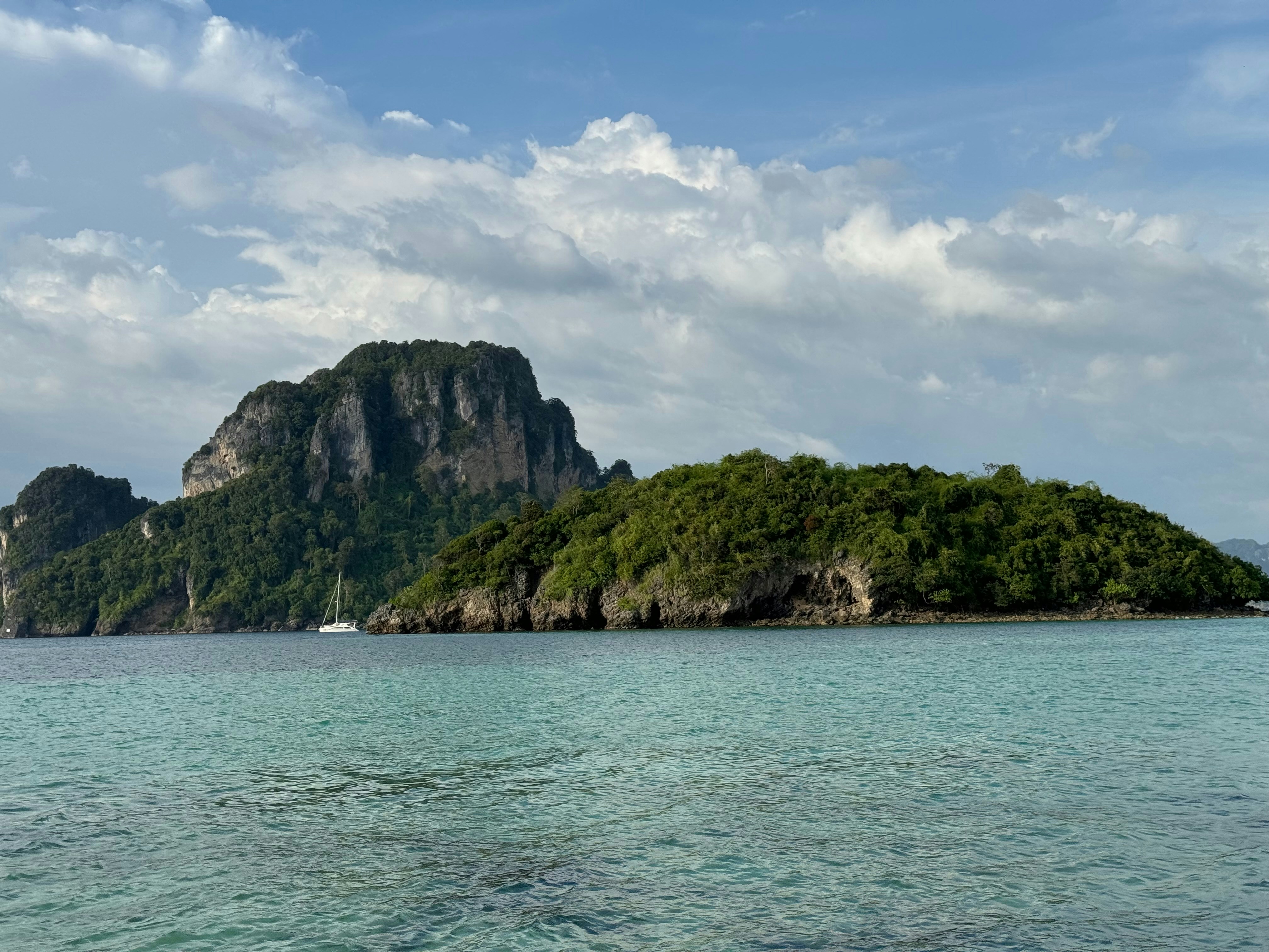 Lush green islands rise from turquoise waters under a partly cloudy sky.