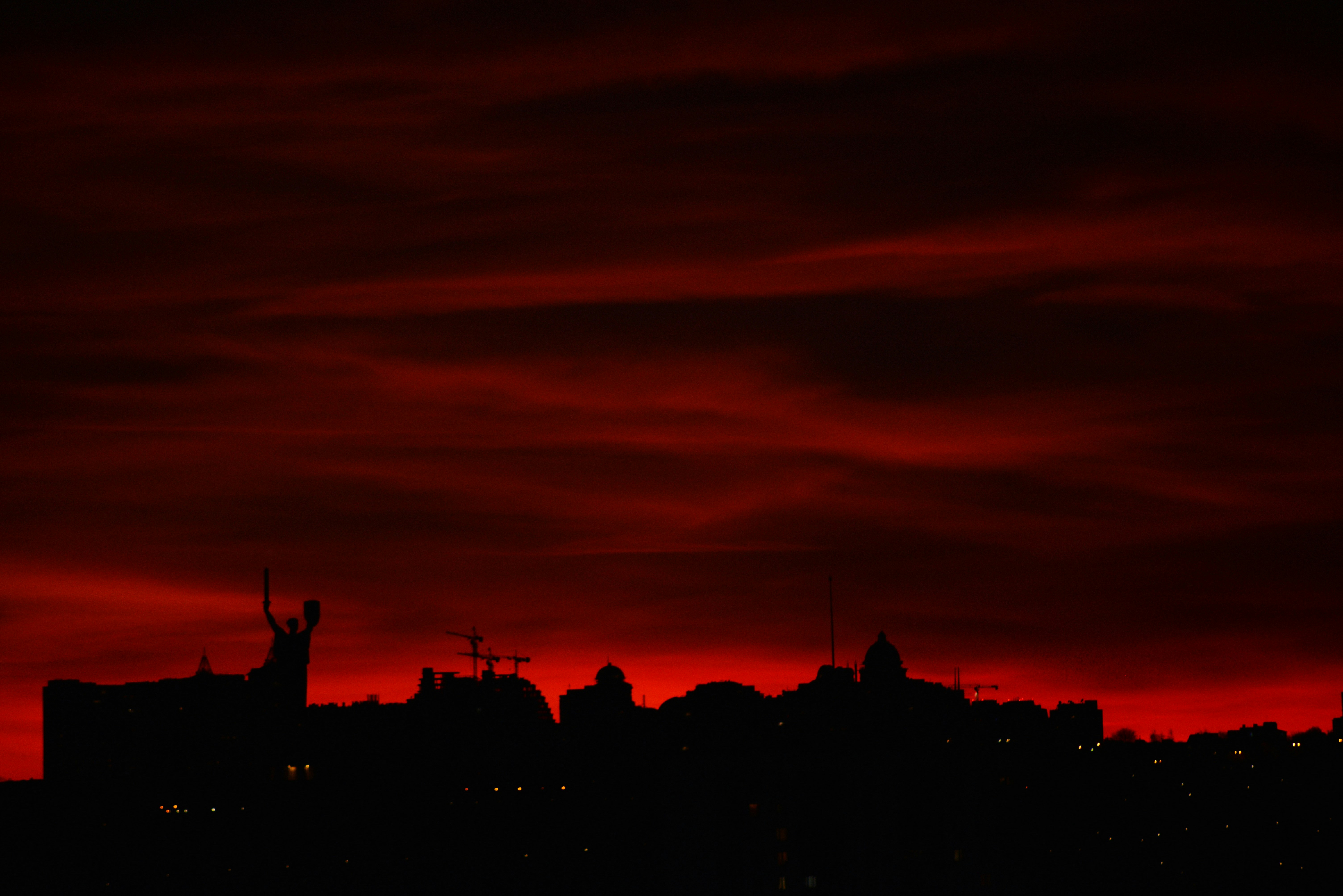 Crimson Veil Over Urban Silhouette