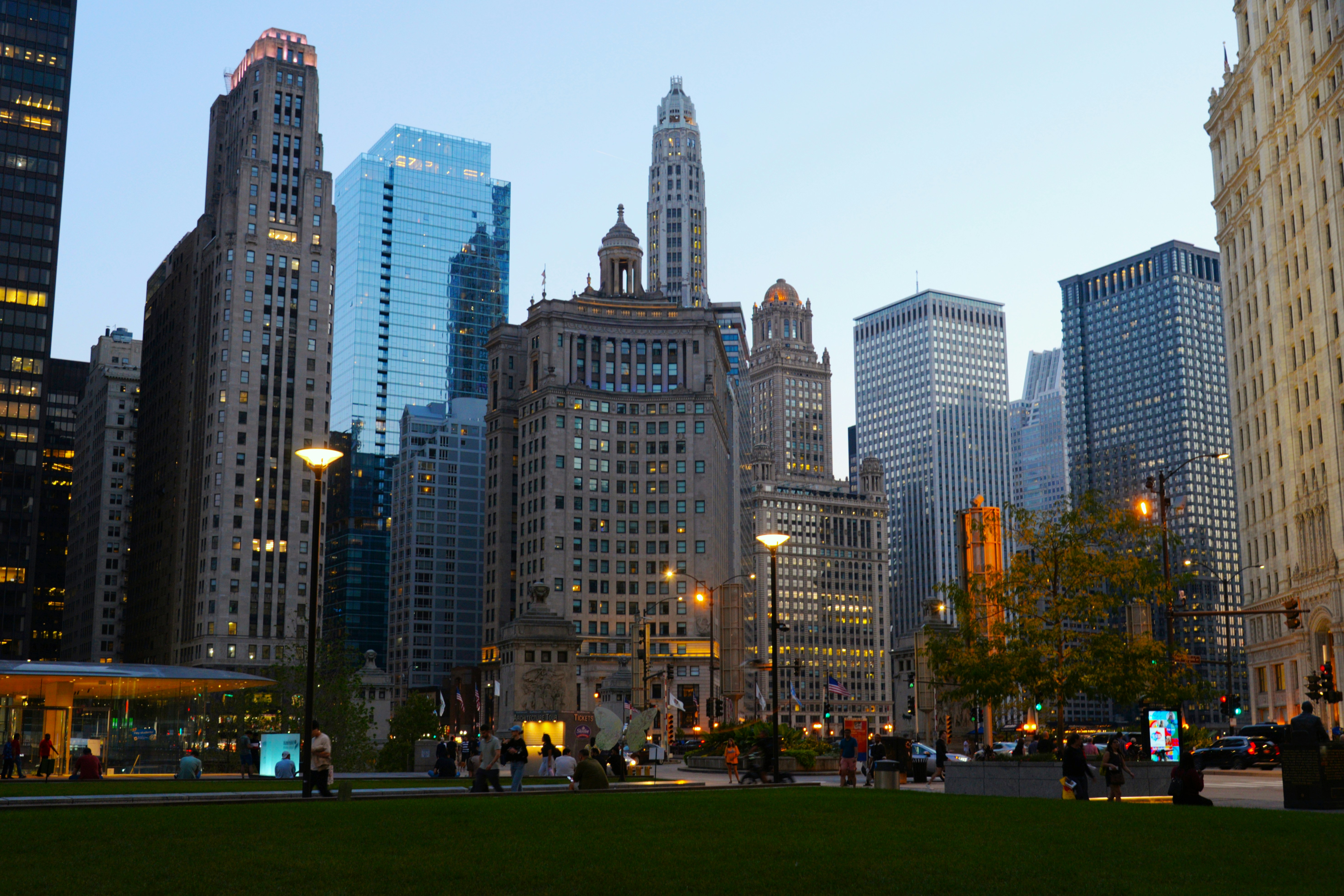City skyline at dusk with illuminated skyscrapers and evening sky.