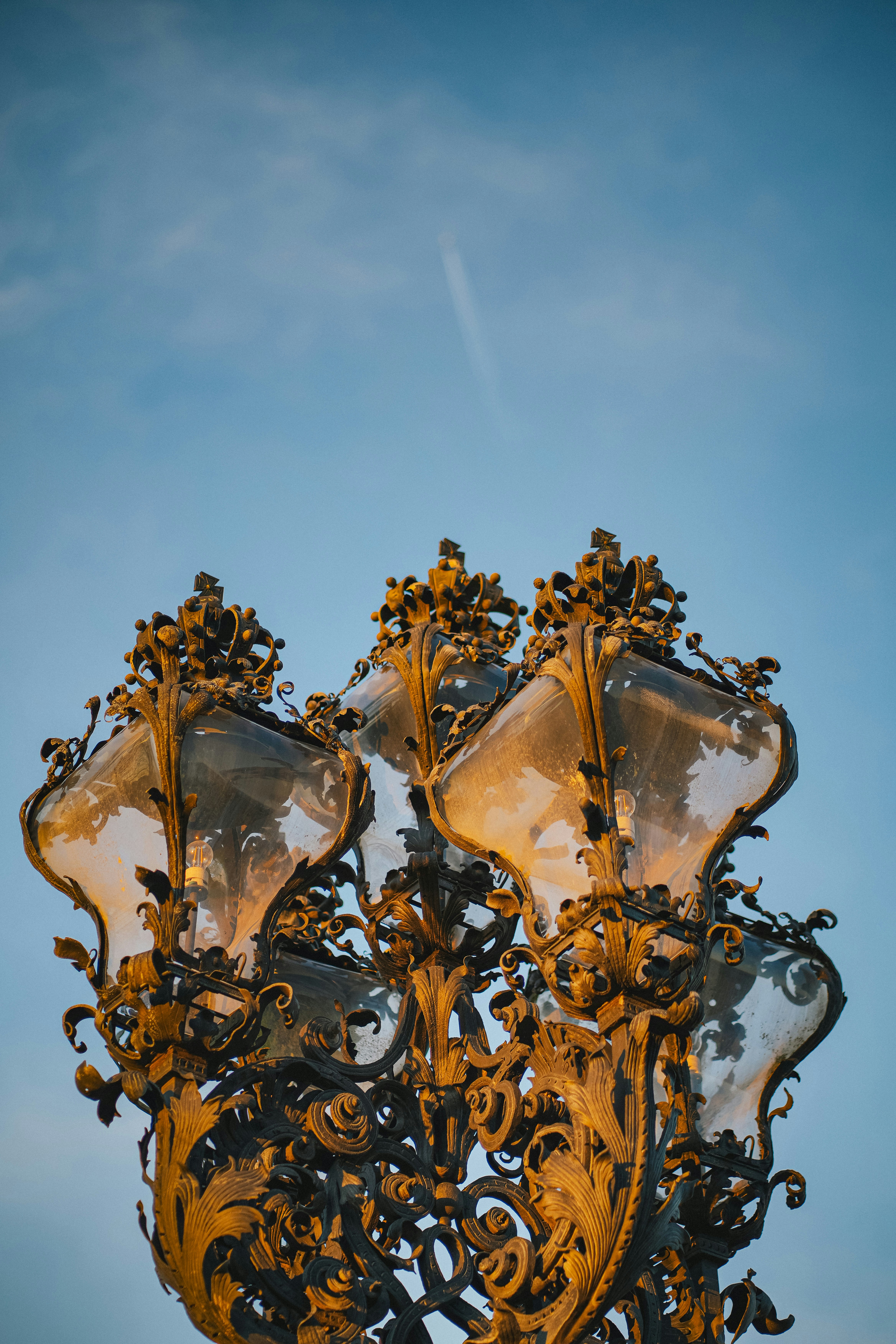 Bronze Lanterns Against Cerulean Sky: Intricate Ironwork in Daylight