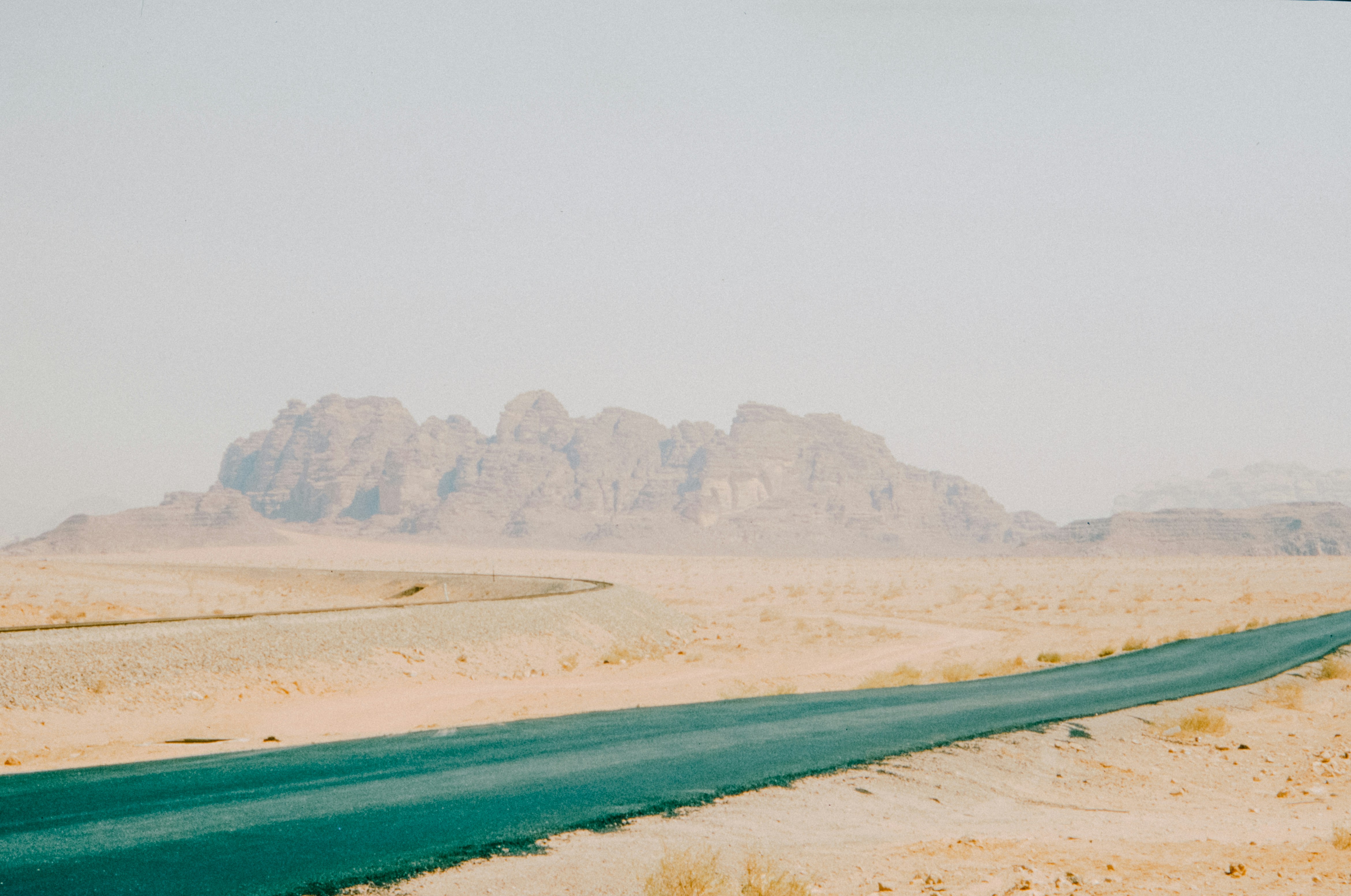 A road stretches across a dusty desert landscape. photo – Free Vintage ...