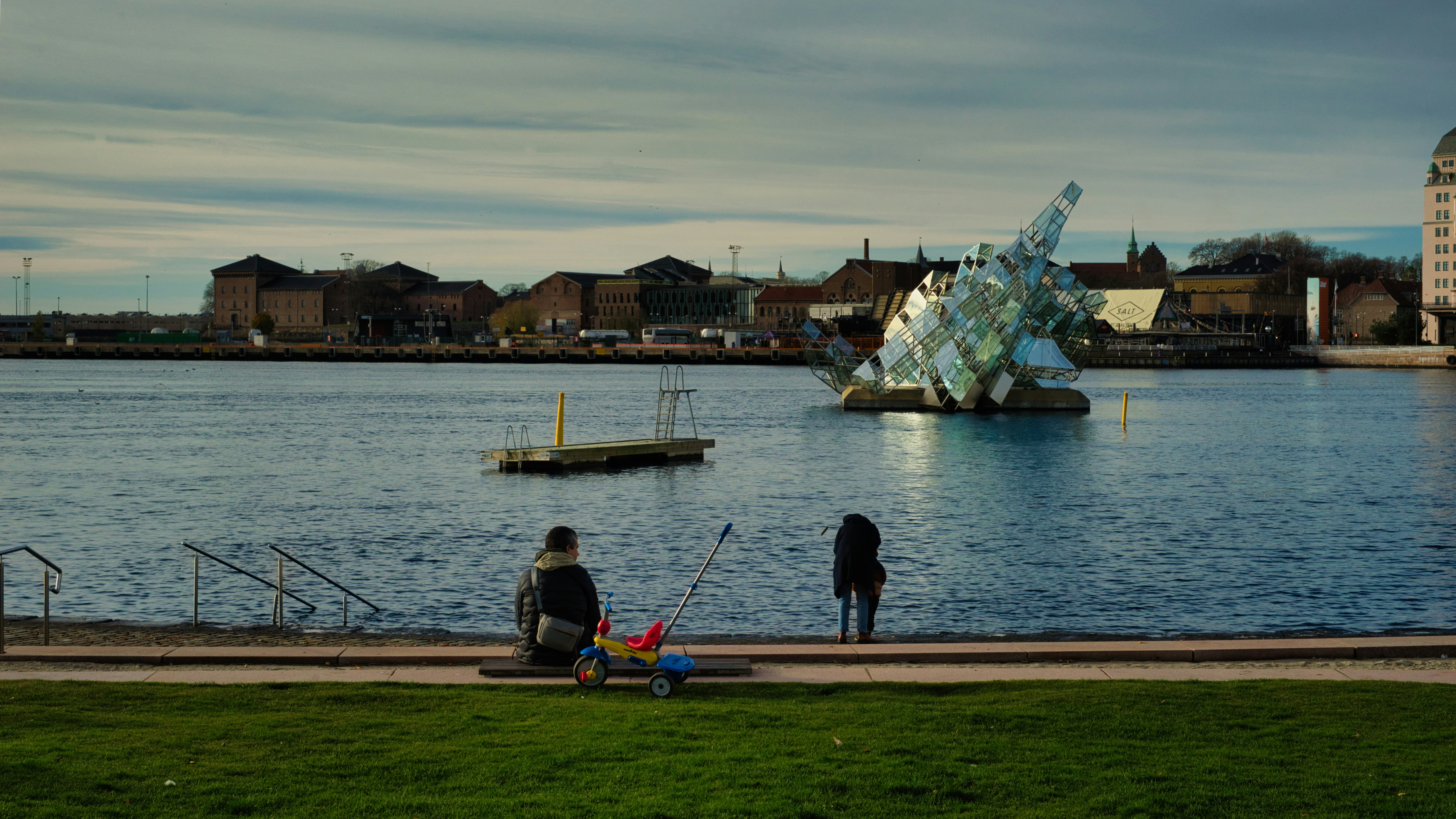 Fragmented sculpture anchors a quiet lakeside promenade