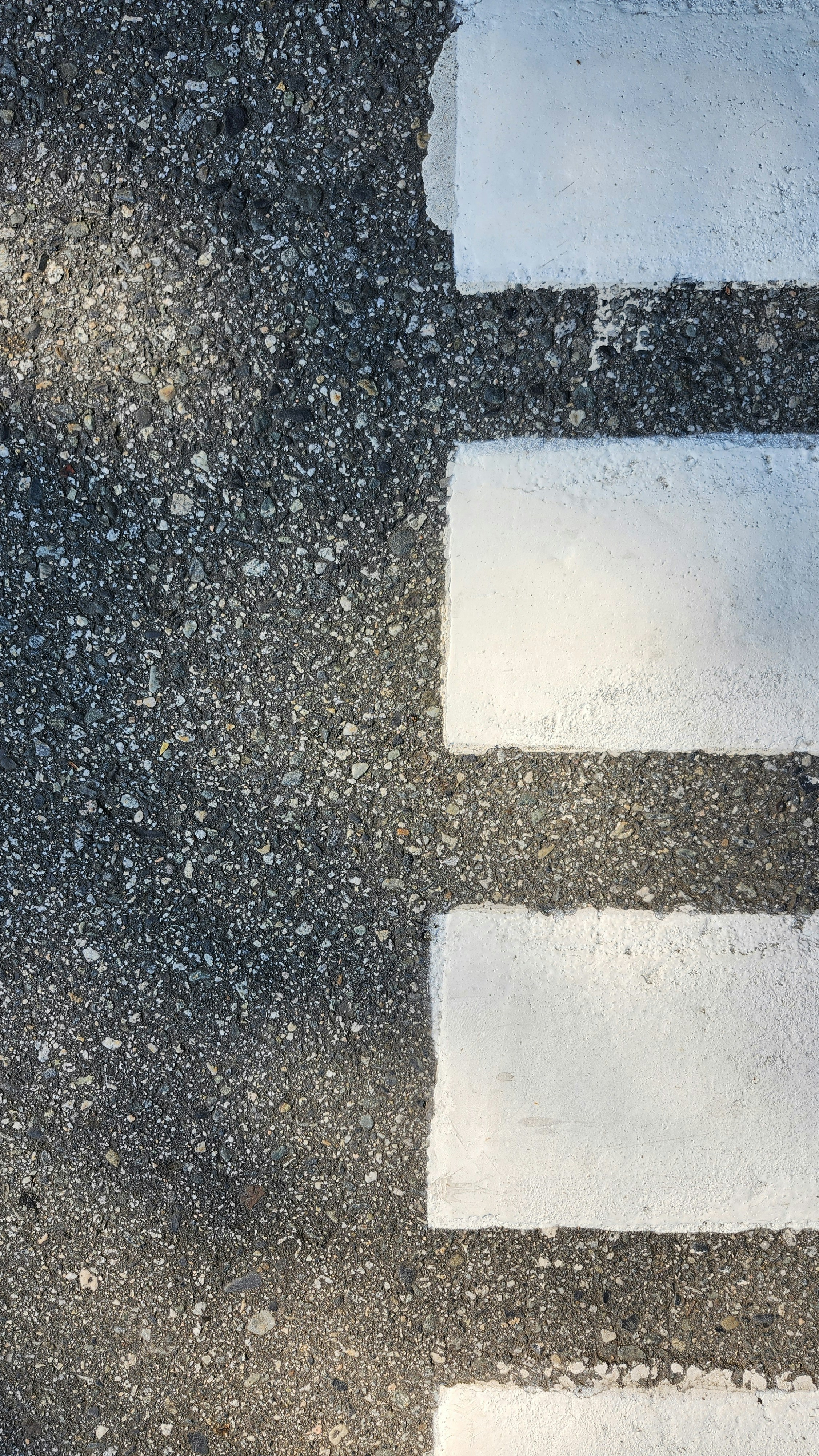 Pedestrian crossing, white on gray, asphalt, urban setting