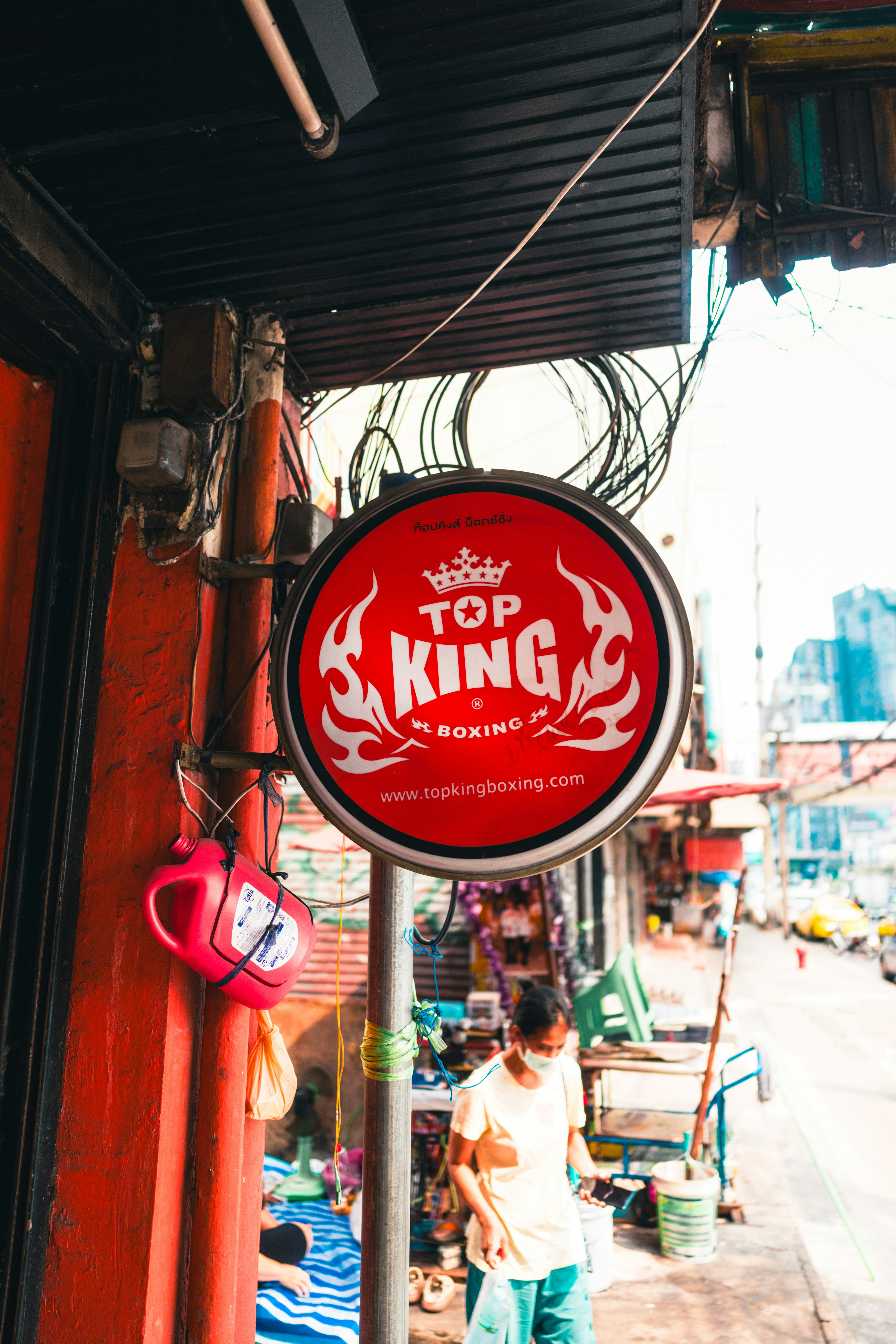 Neon Crown of the Alley: The Top King Boxing Sign Amidst Wires and Urban Heat
