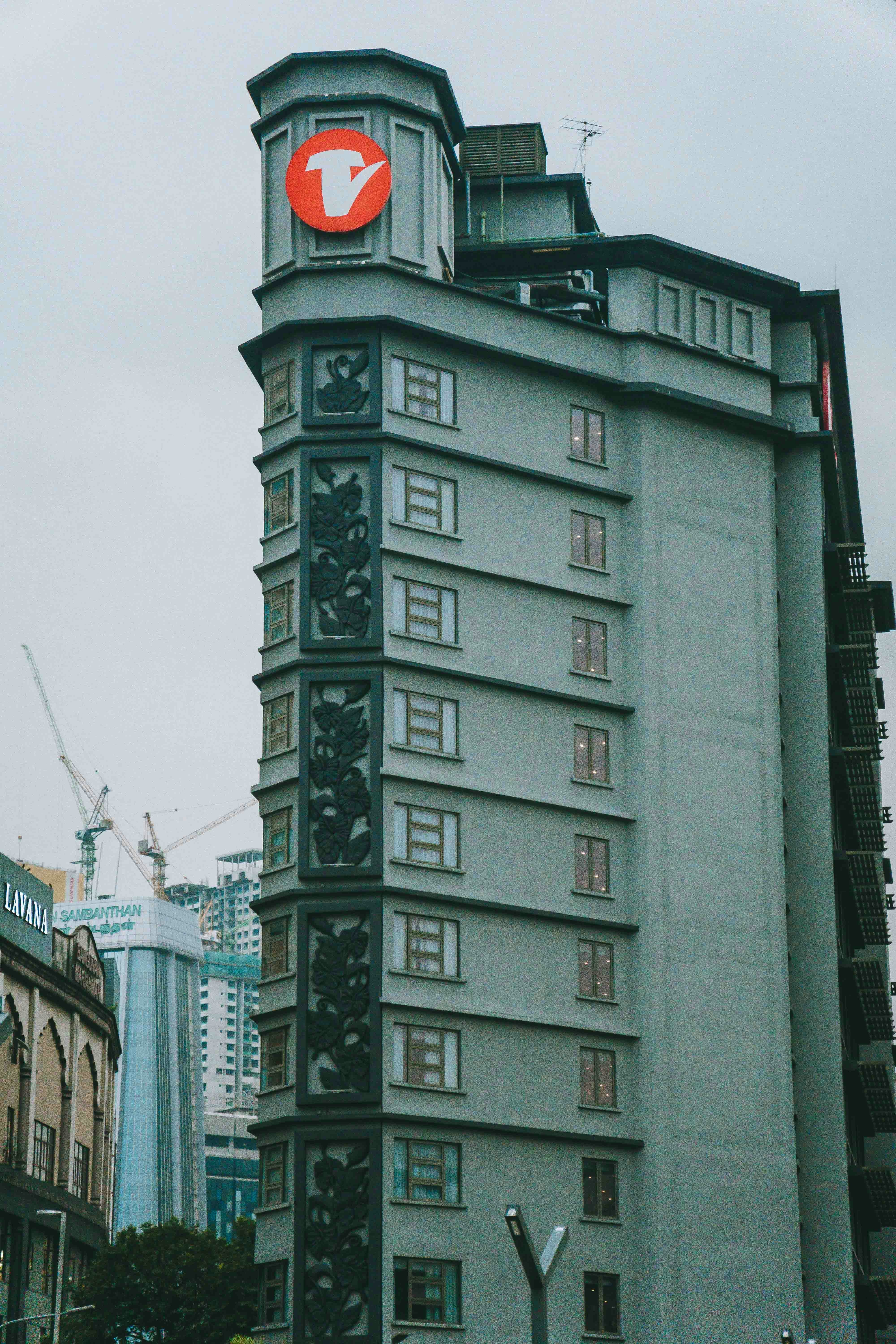 Red Crest Over Grey Facade: A City High-Rise with a Distinctive Circular Logo