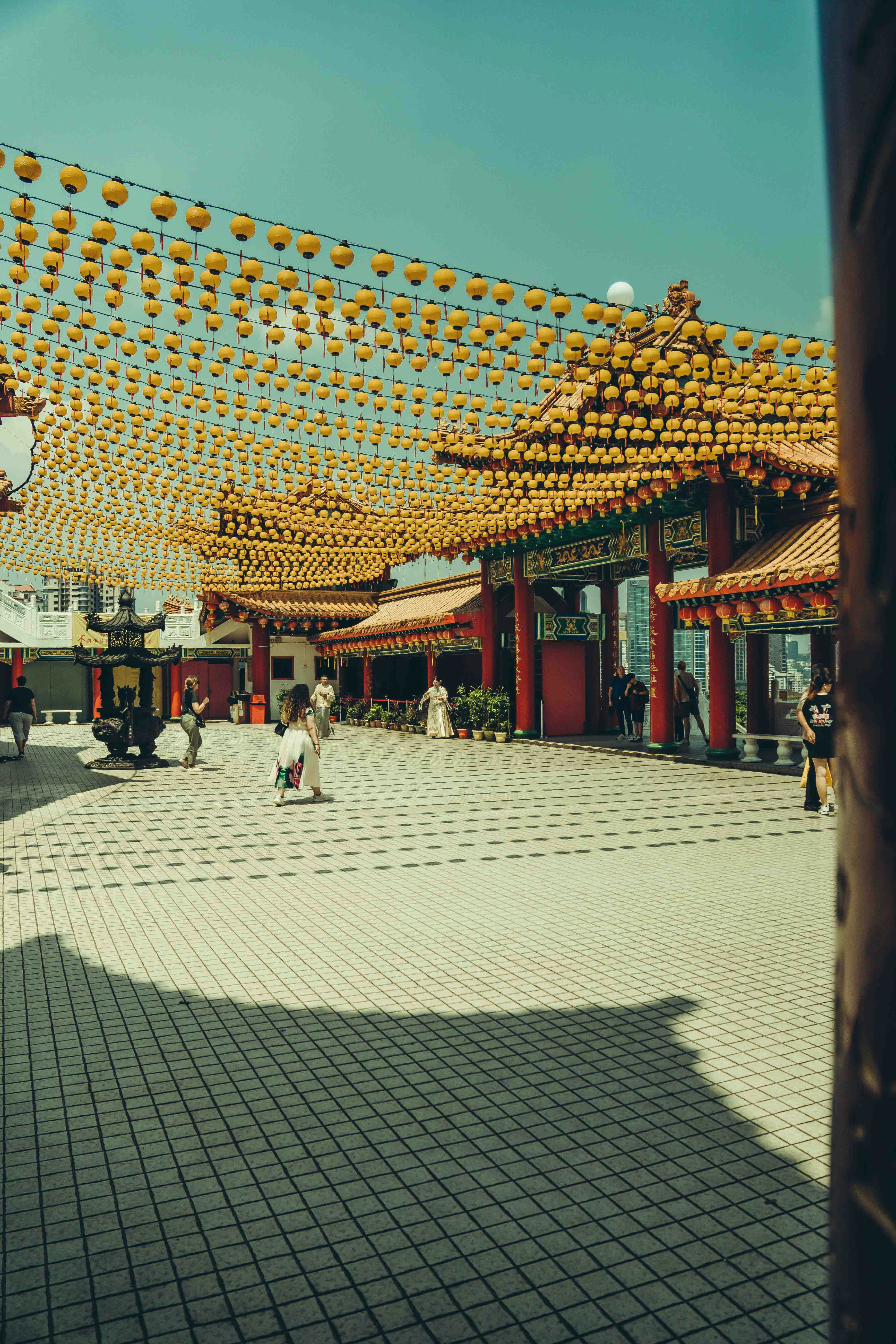 Lantern Canopy Draped Across a Sunlit Temple Courtyard