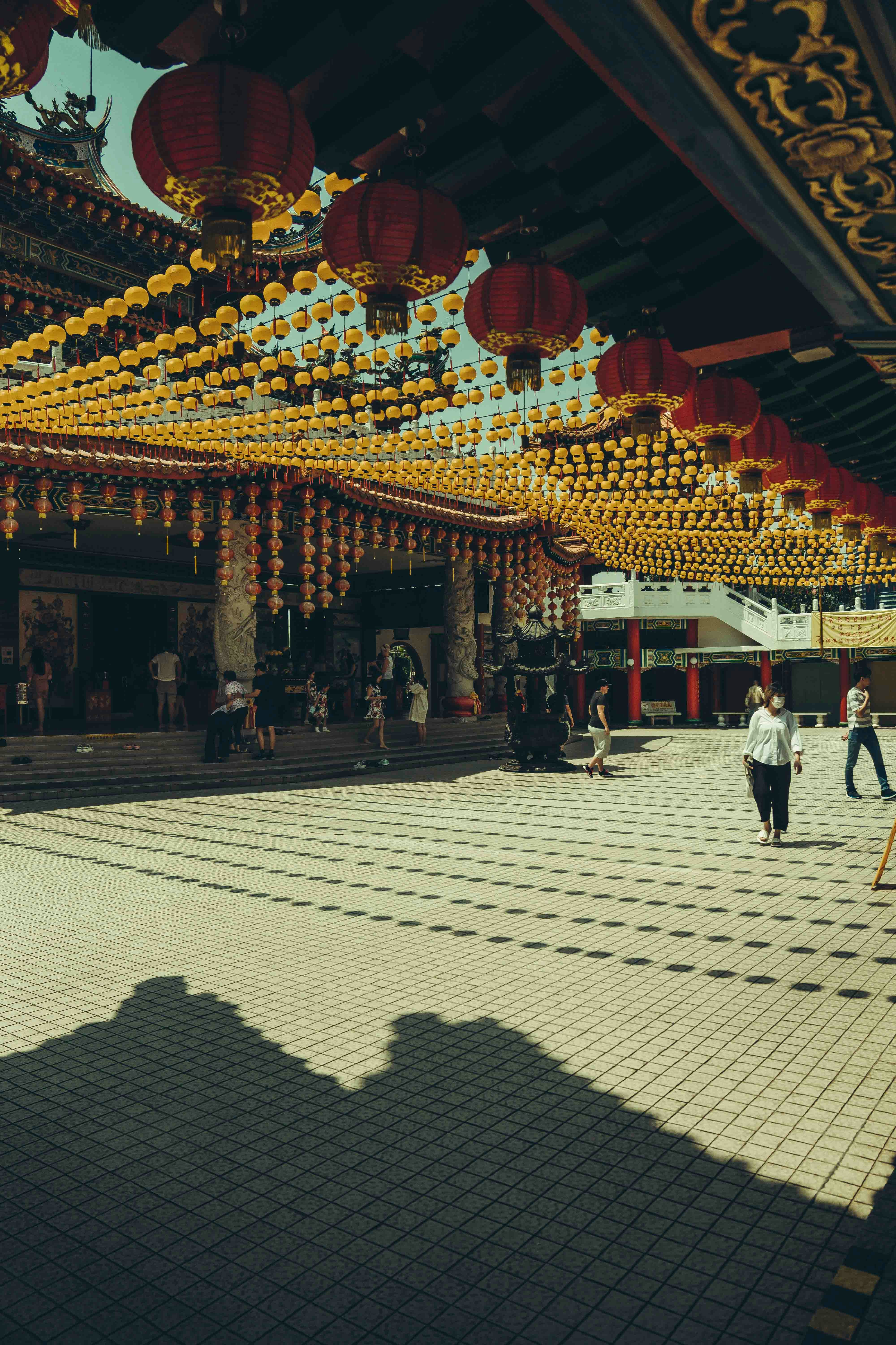 Lantern Corridor Over a Temple Courtyard: Red and Gold Orbs Framing Quiet Footsteps