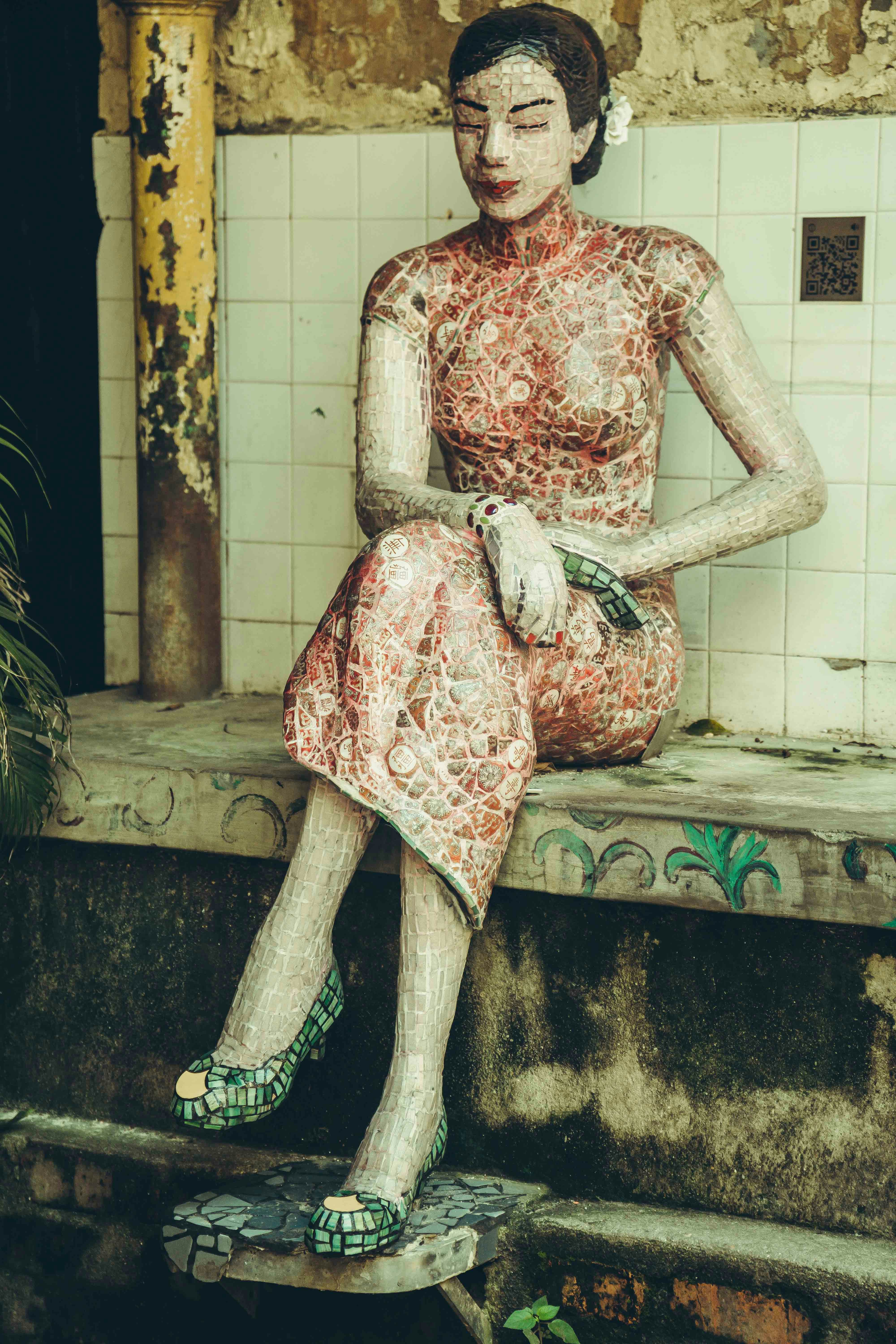 Mosaic in Motion: A seated statue emerges from cracked tiles