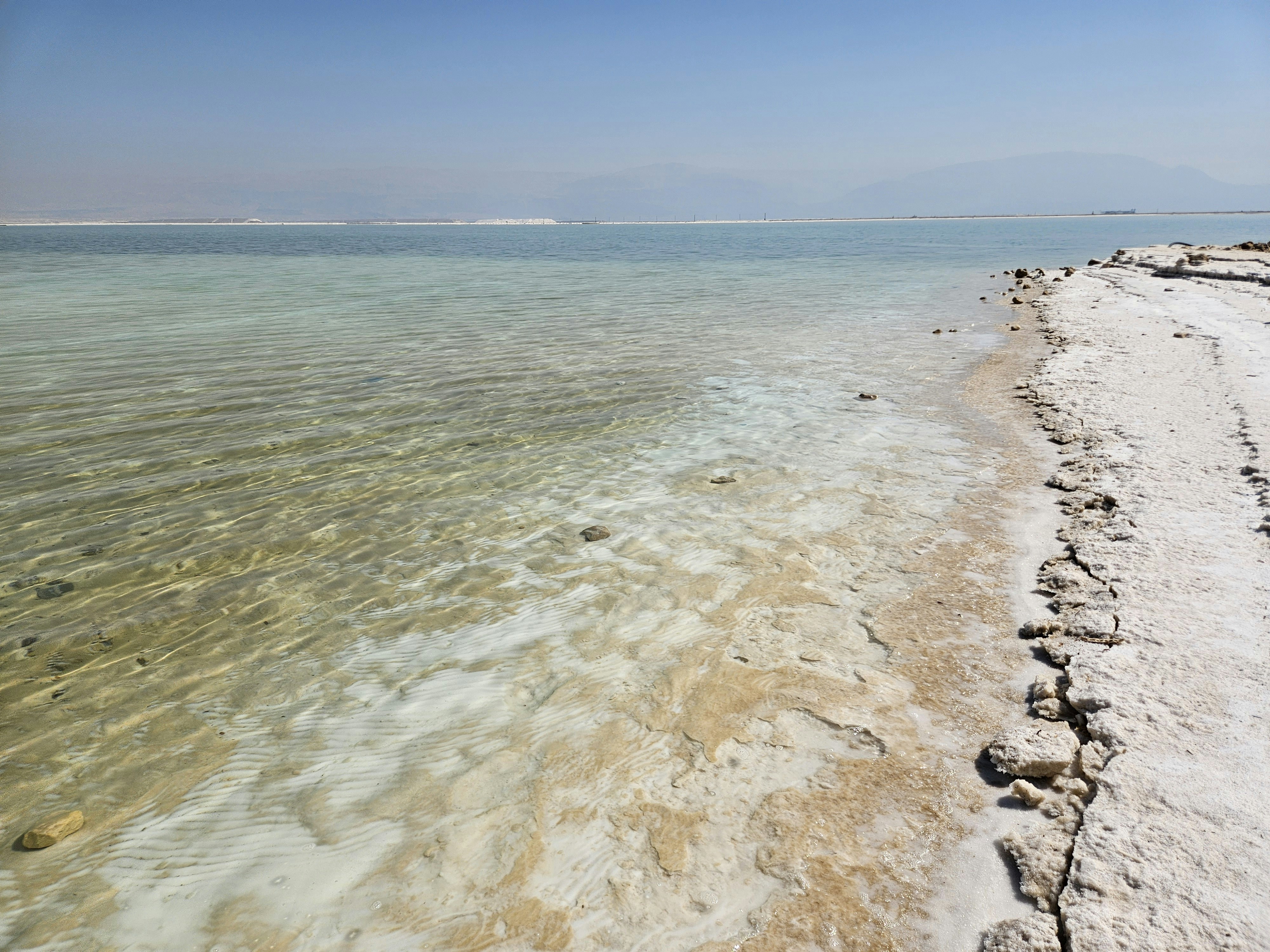 Dead sea's shoreline showing salt formations and clear water. photo ...