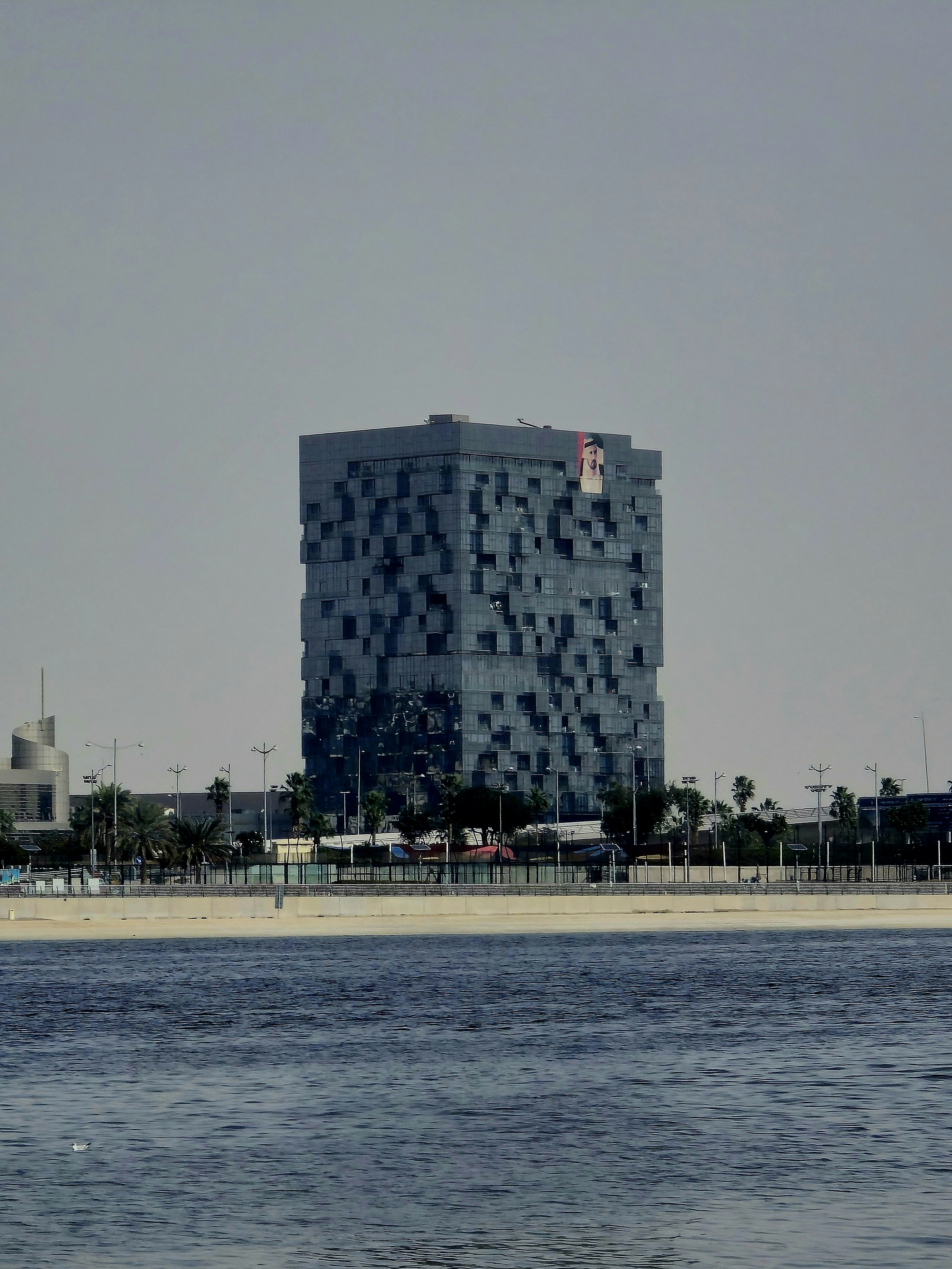 The Faceted Harbor Cube: A Glass-Walled Tower at the Water's Edge