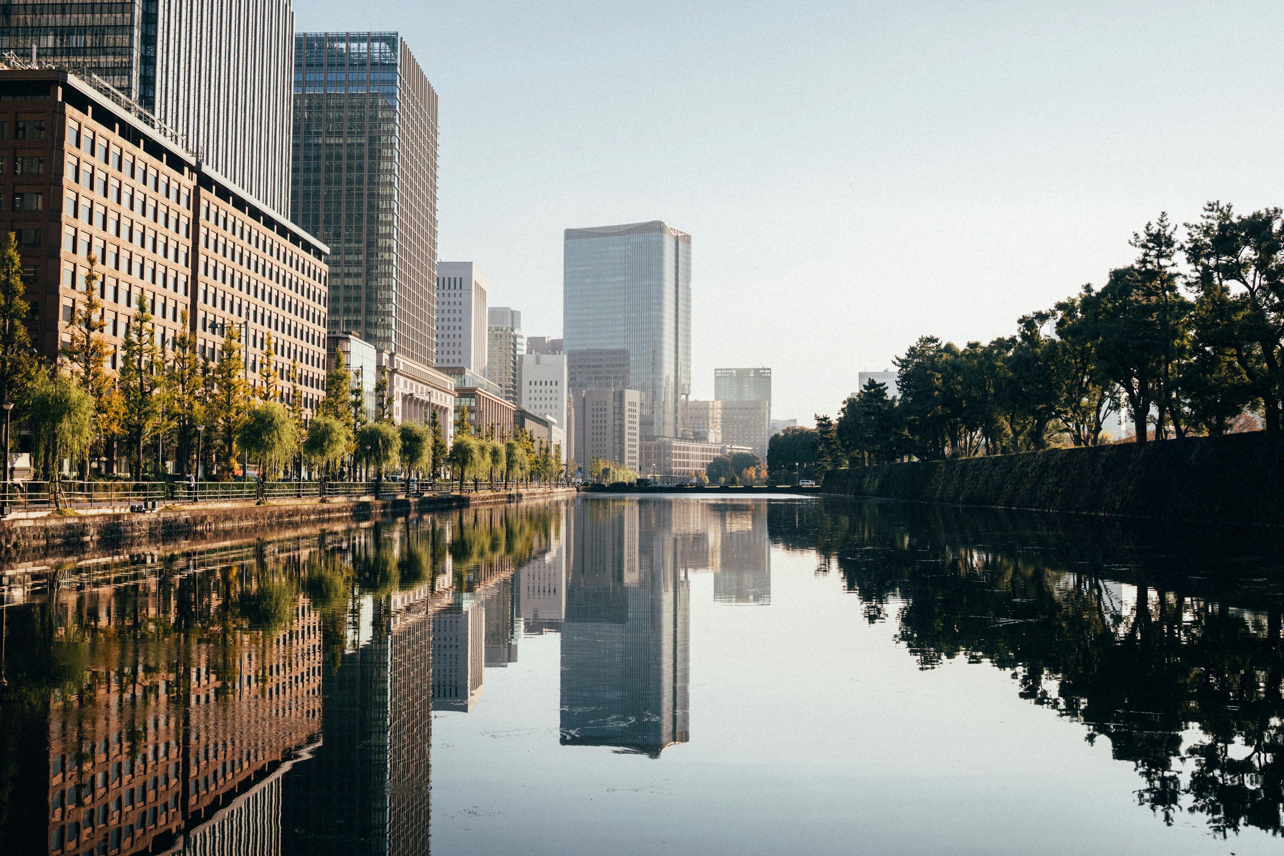 Buildings reflect beautifully in a calm river. photo – Free Building ...