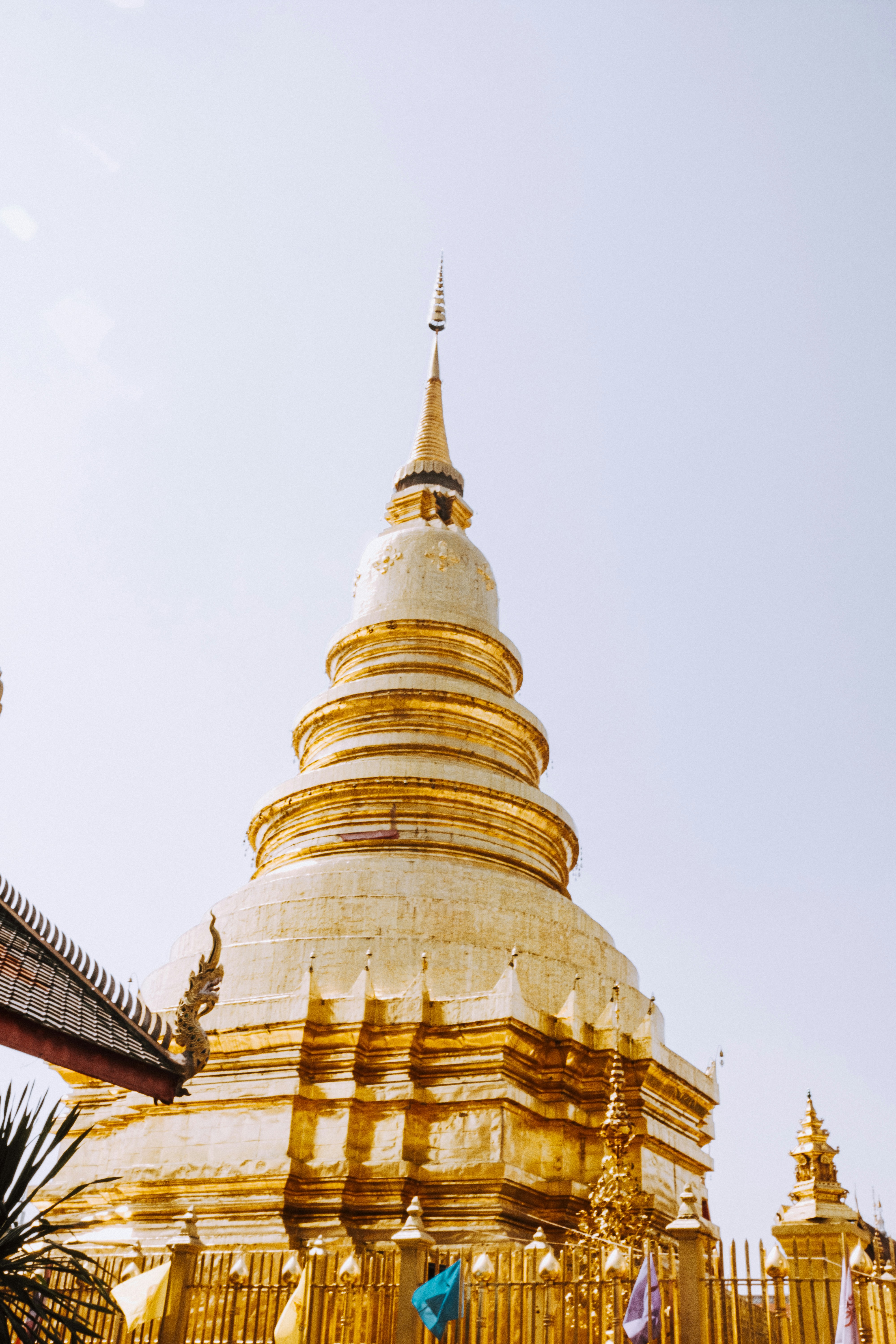 Golden stupa of Wat Phra That Hariphunchai against a clear blue sky in Thailand.