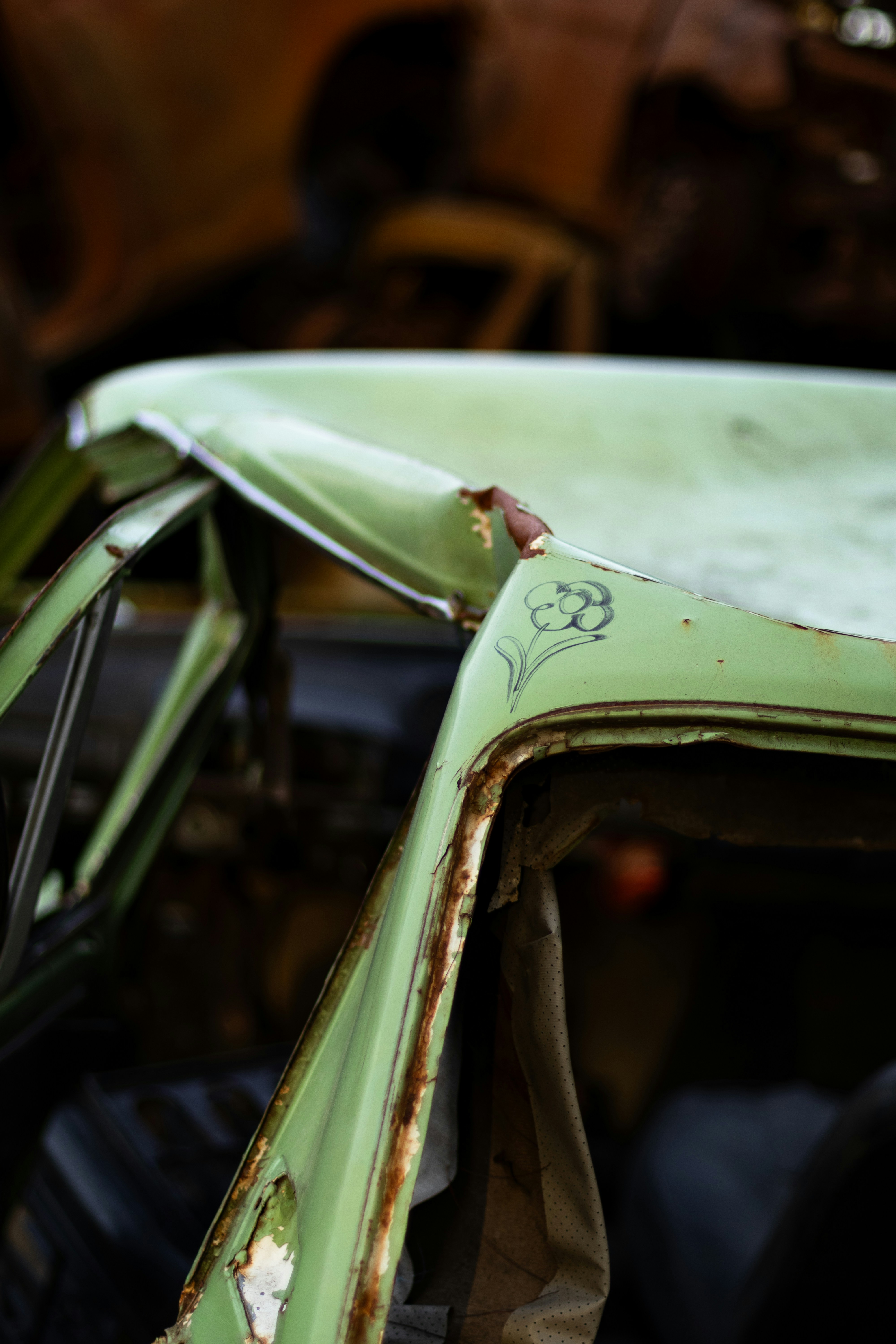 Flaked Green Corner: rusted vintage car with a delicate flower doodle