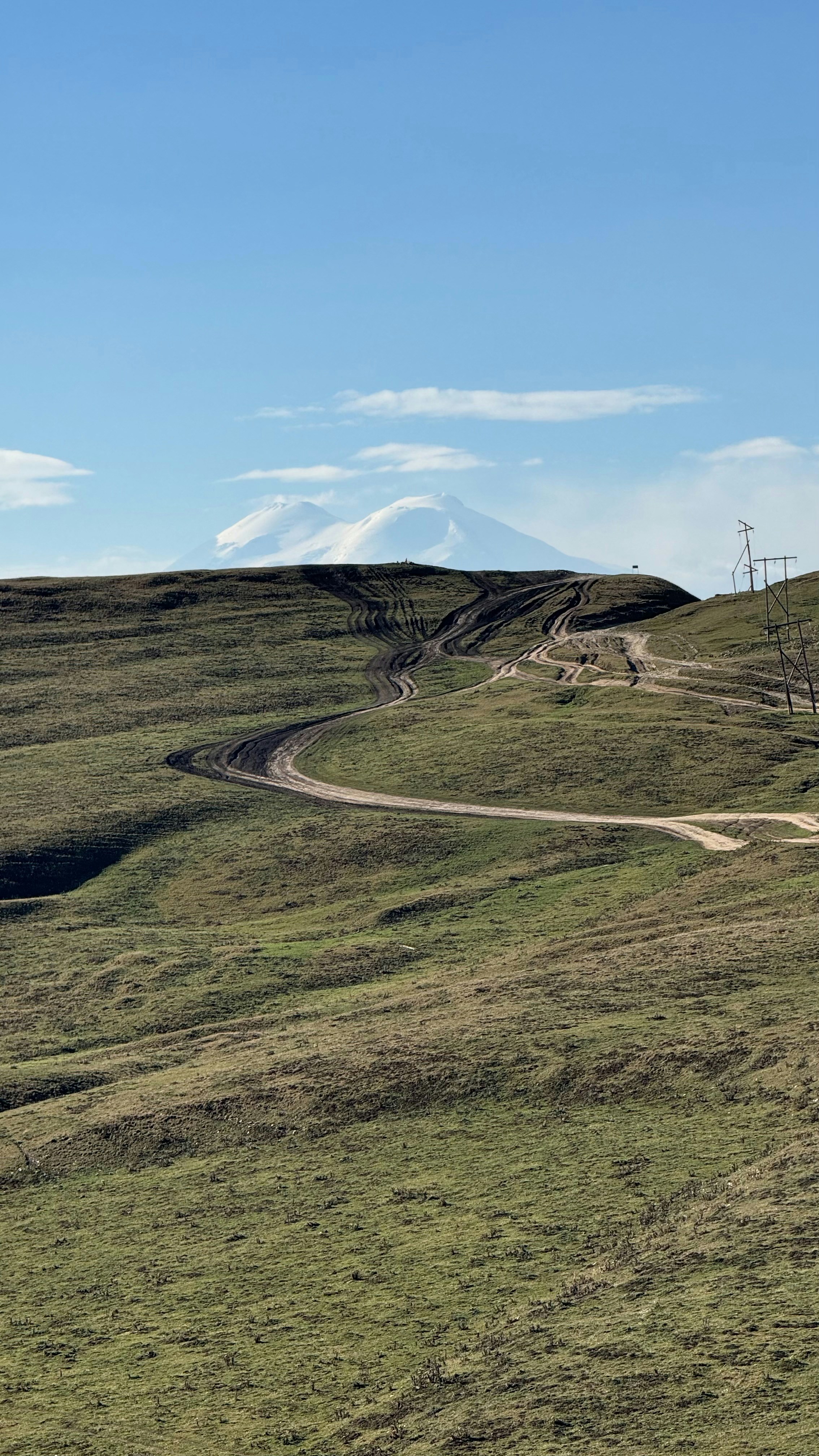 Winding Ridge Road Toward Snow-Capped Peaks