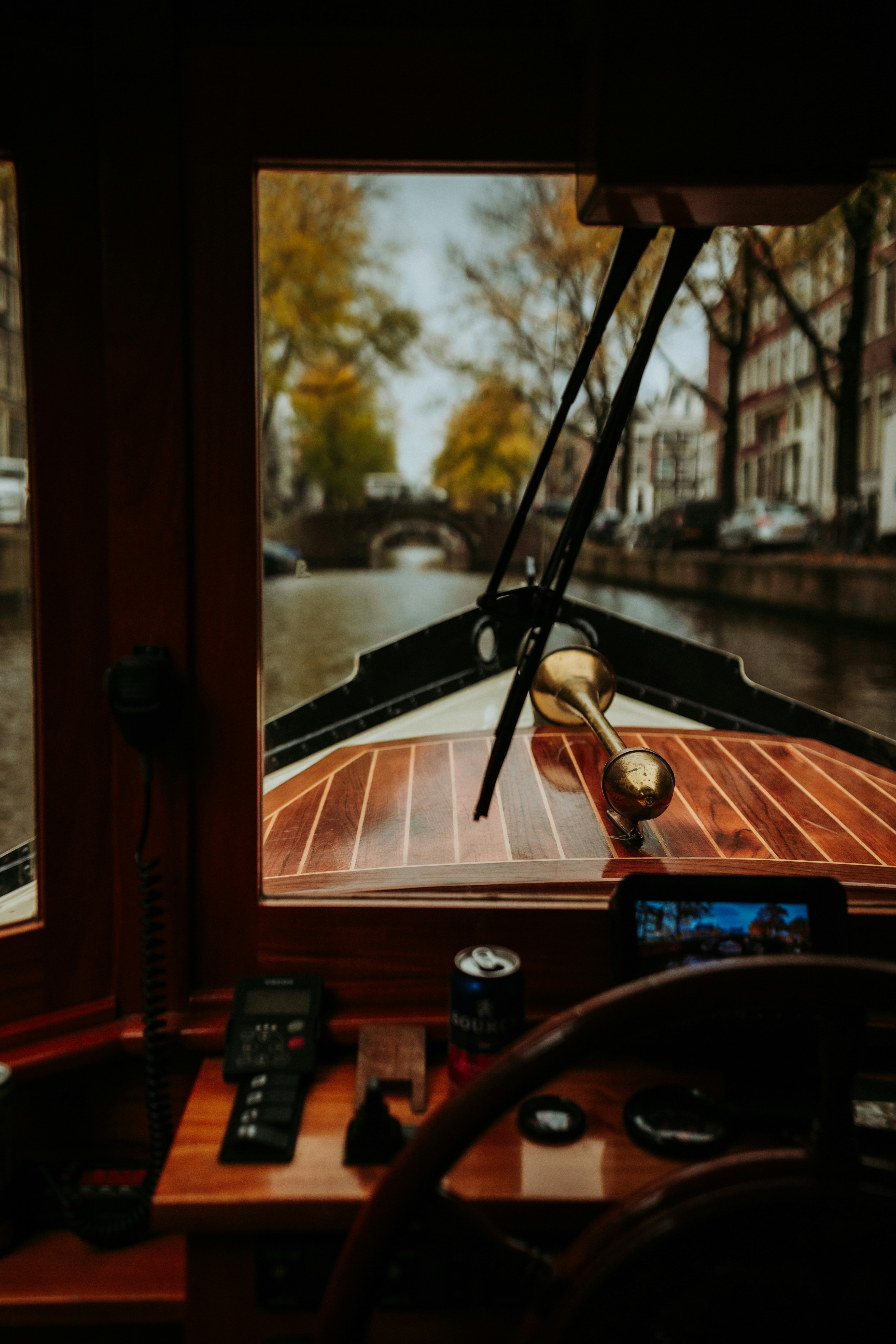 Brass Helm in Focus: Autumn Canal Scene from a Cozy Cabin