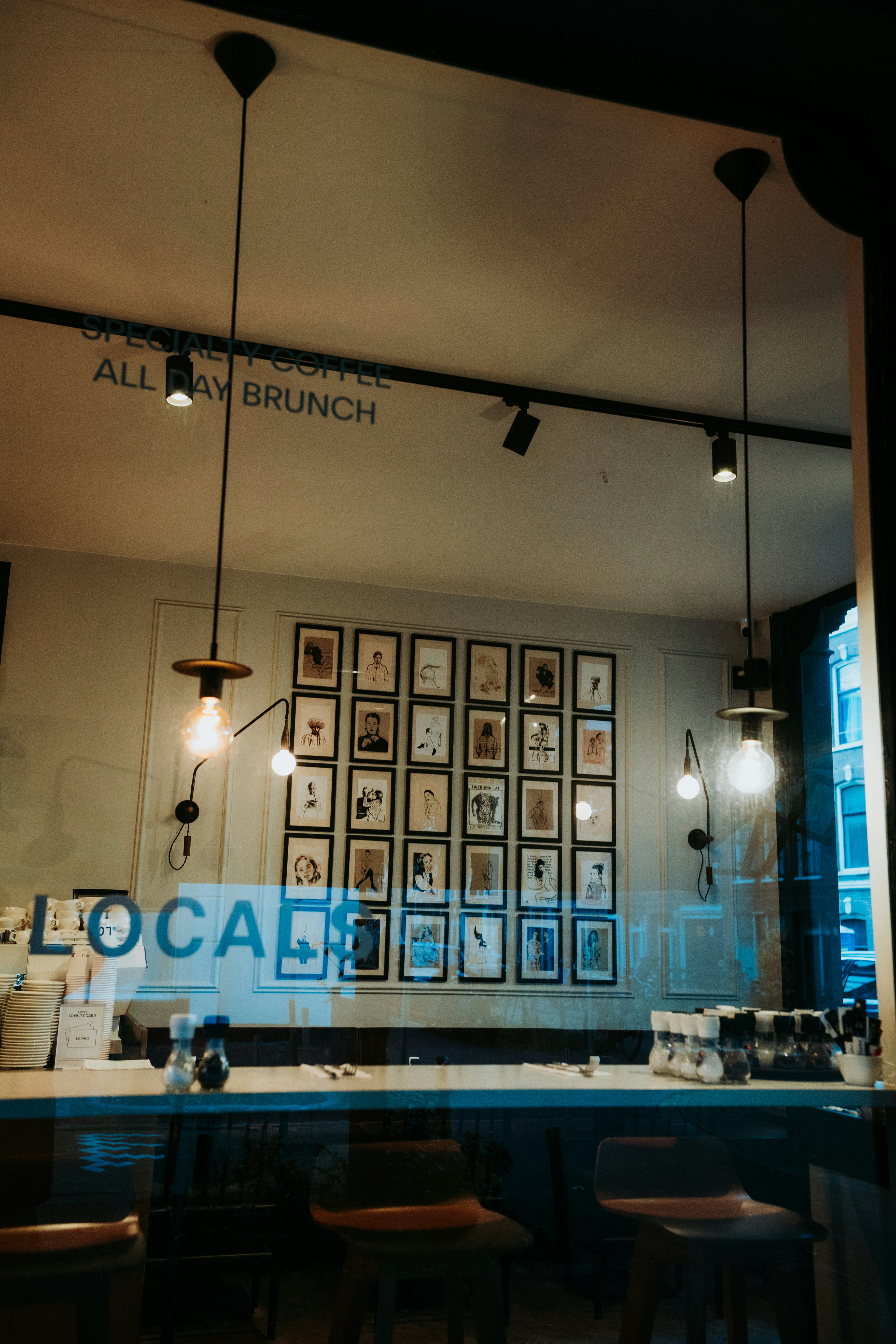 Portrait Grid in a Cozy Café, Warm Pendants and Blue Glass Reflections