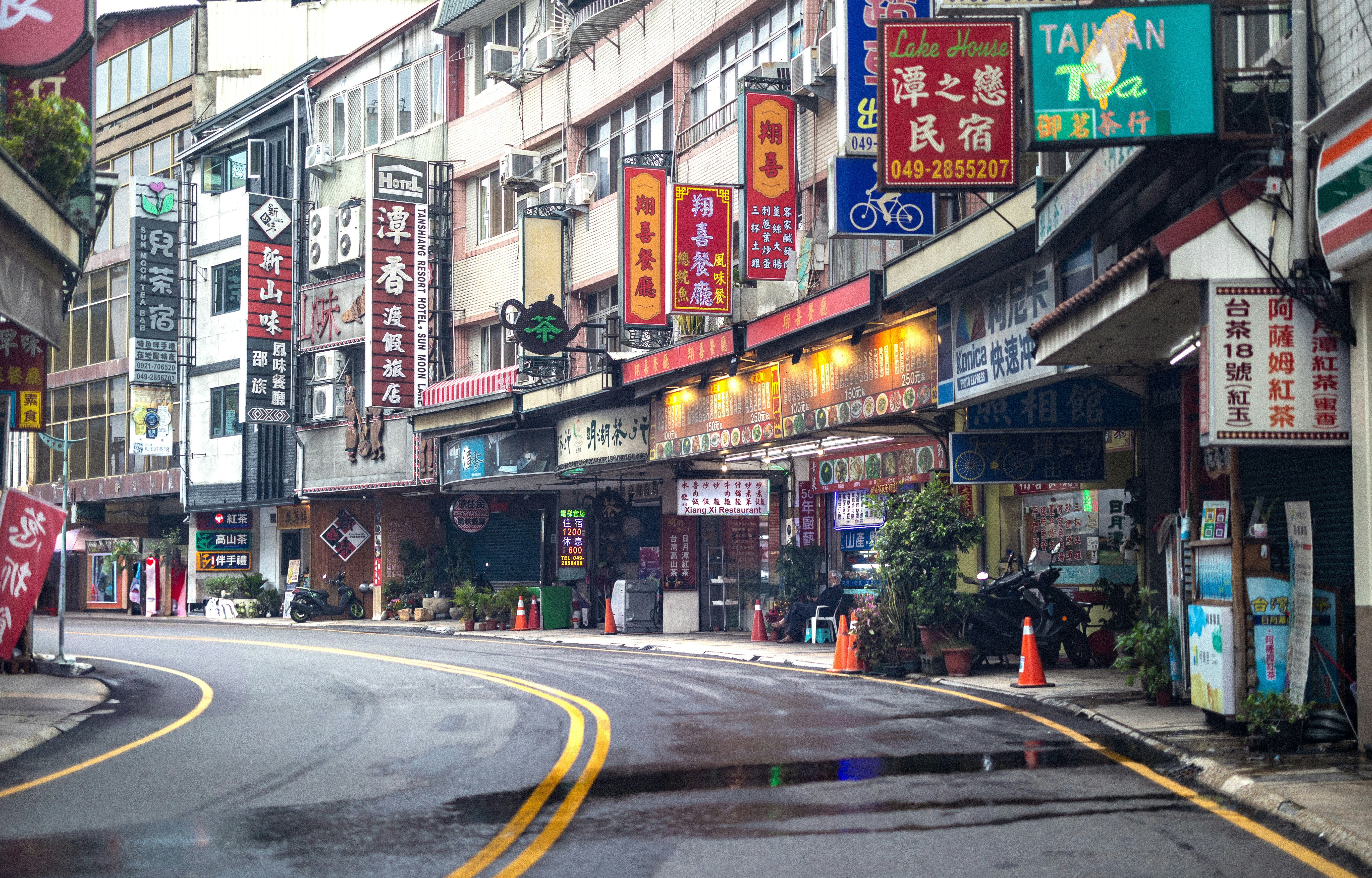 Colorful street with various shop signs and a curved road lined with buildings.