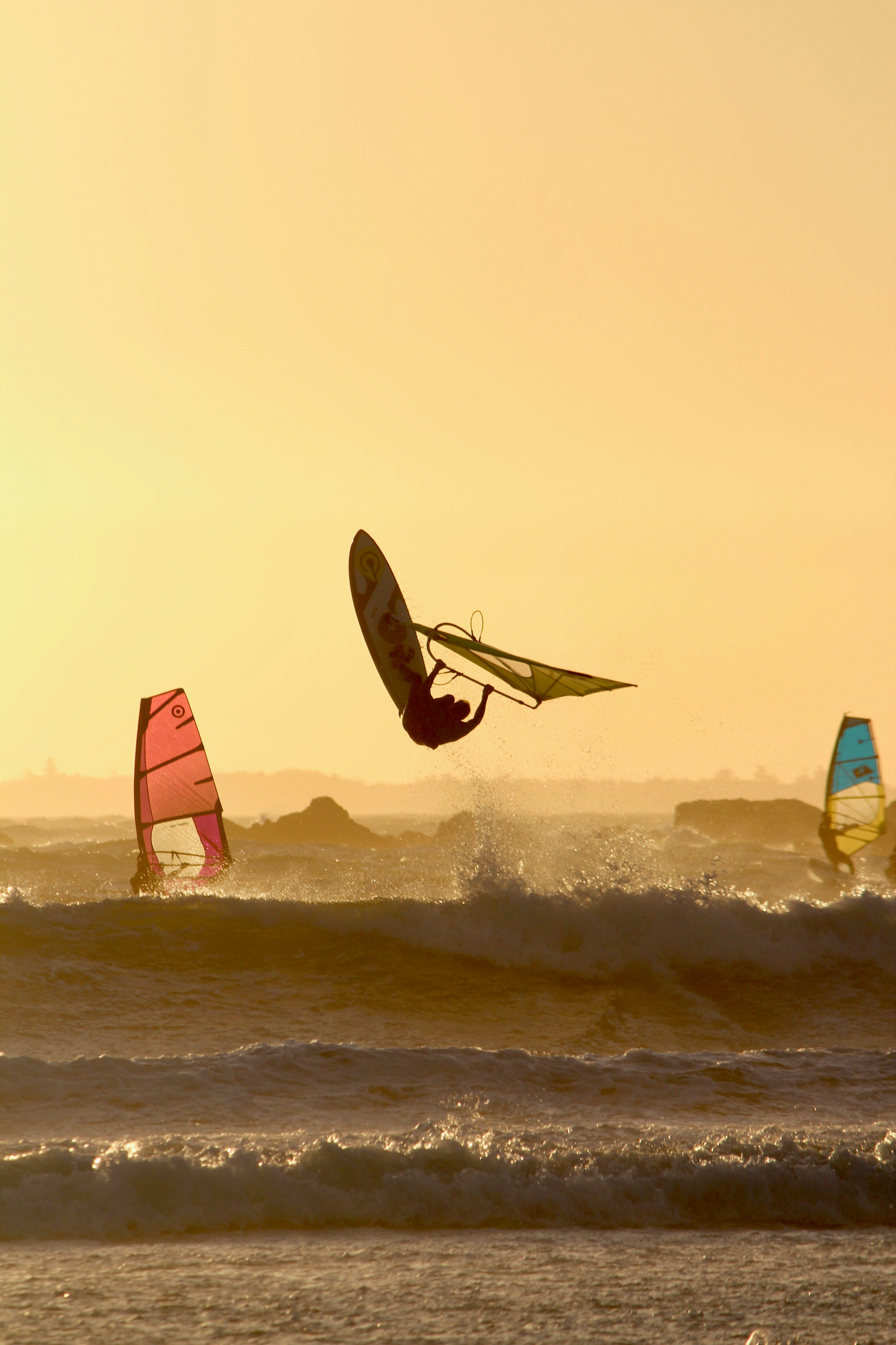Windsurfer soars through the air above waves at sunset. photo – Free ...