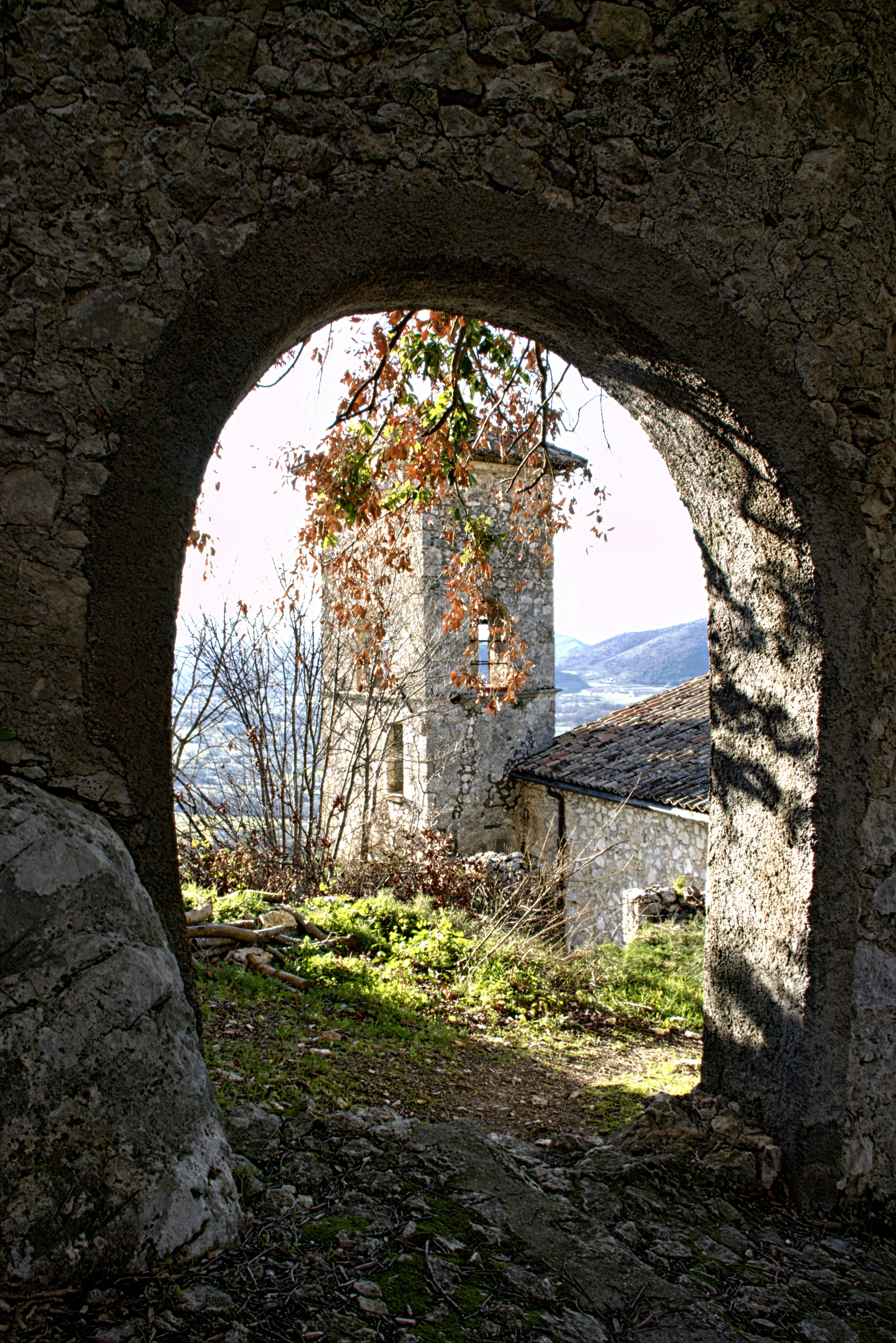 Une tour de pierre est vue à travers une arche de pierre. photo – Image ...