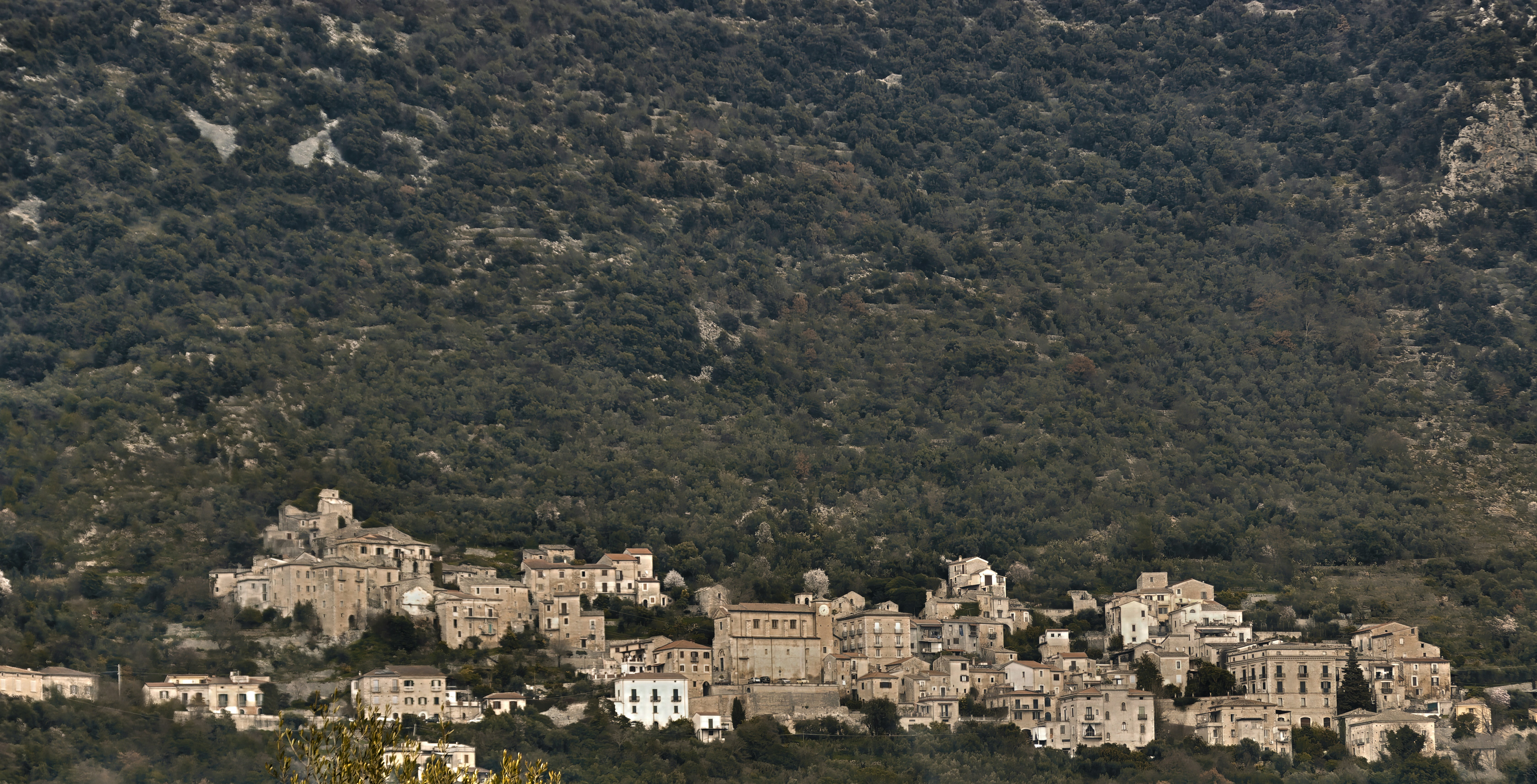 Historic village nestled among lush hills, showcasing a blend of natural beauty and architectural heritage.