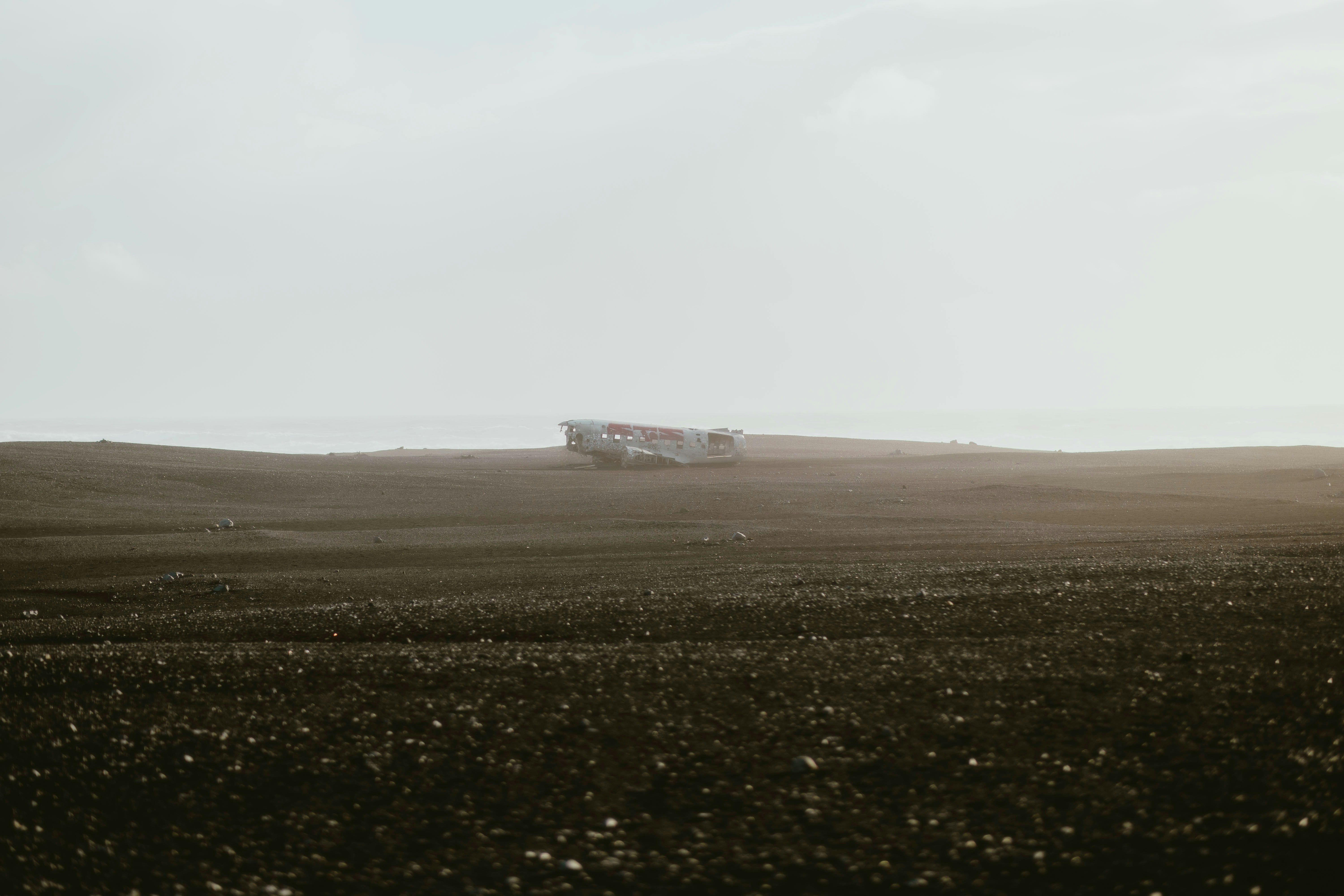 A field stretches toward the horizon with a structure. photo – Free ...