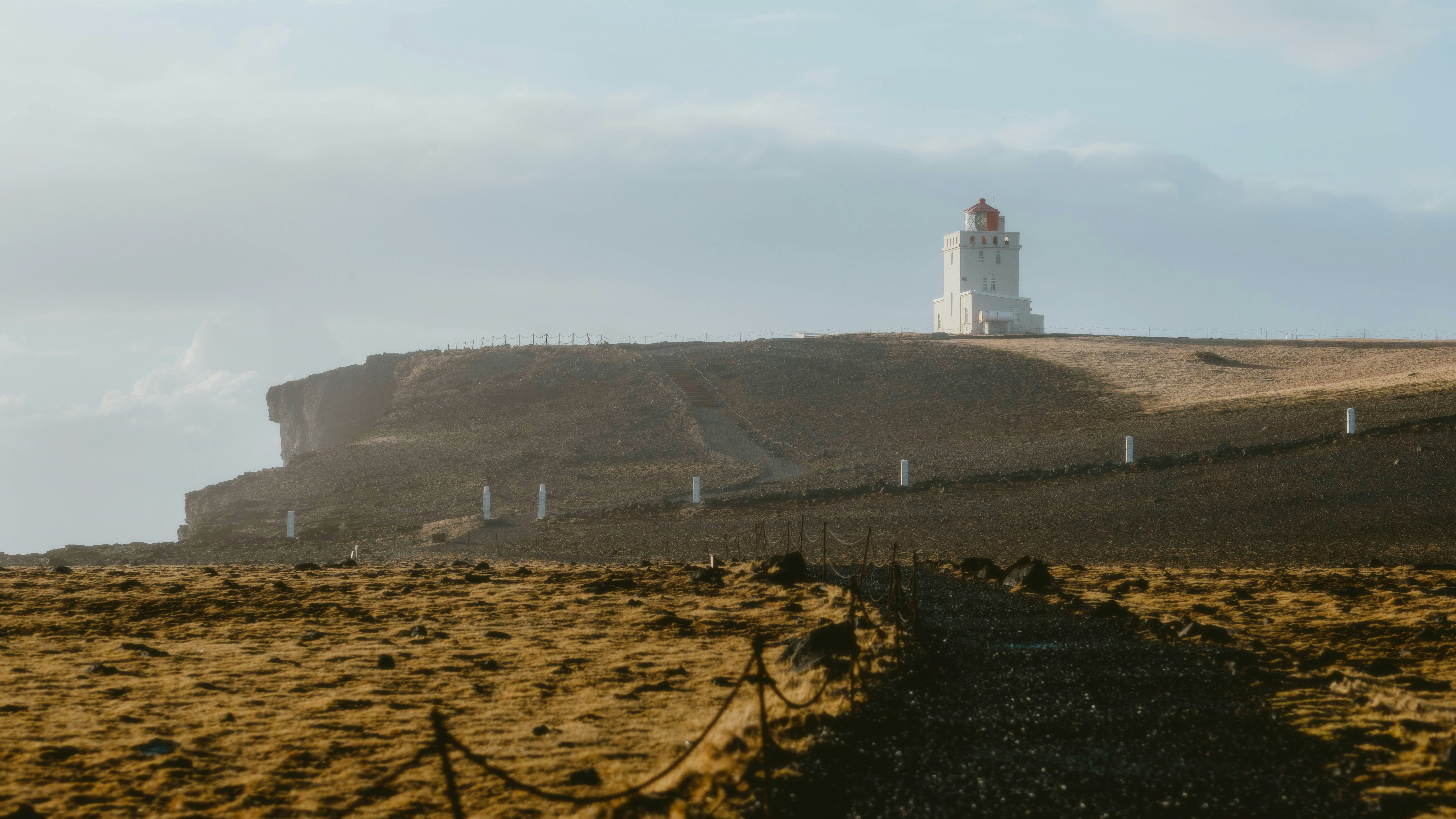 Beacon on the Wind-Swept Promontory: Lighthouse Over a Quiet Dune Horizon