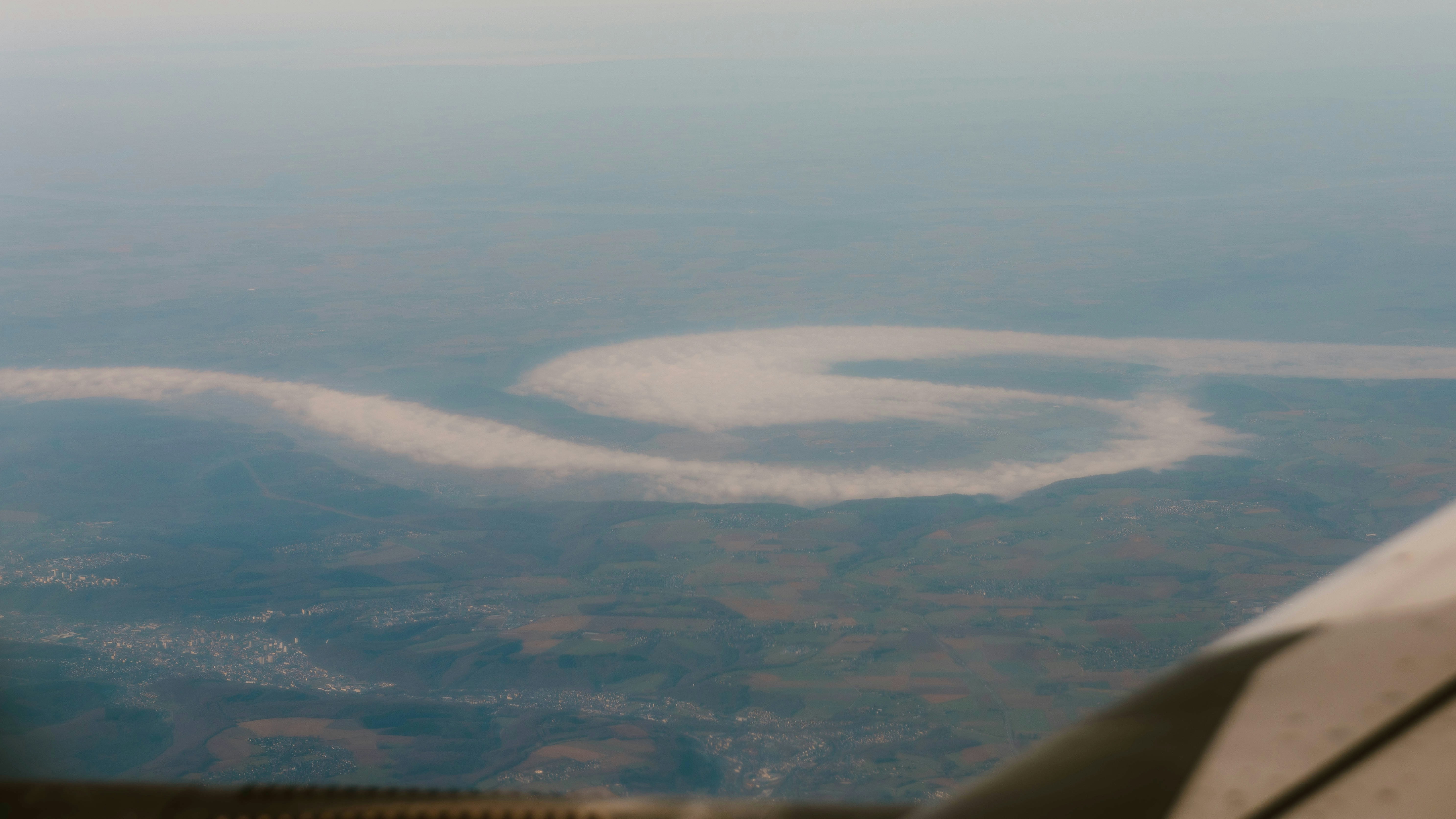 Serpentine Clouds Over Verdant Fields