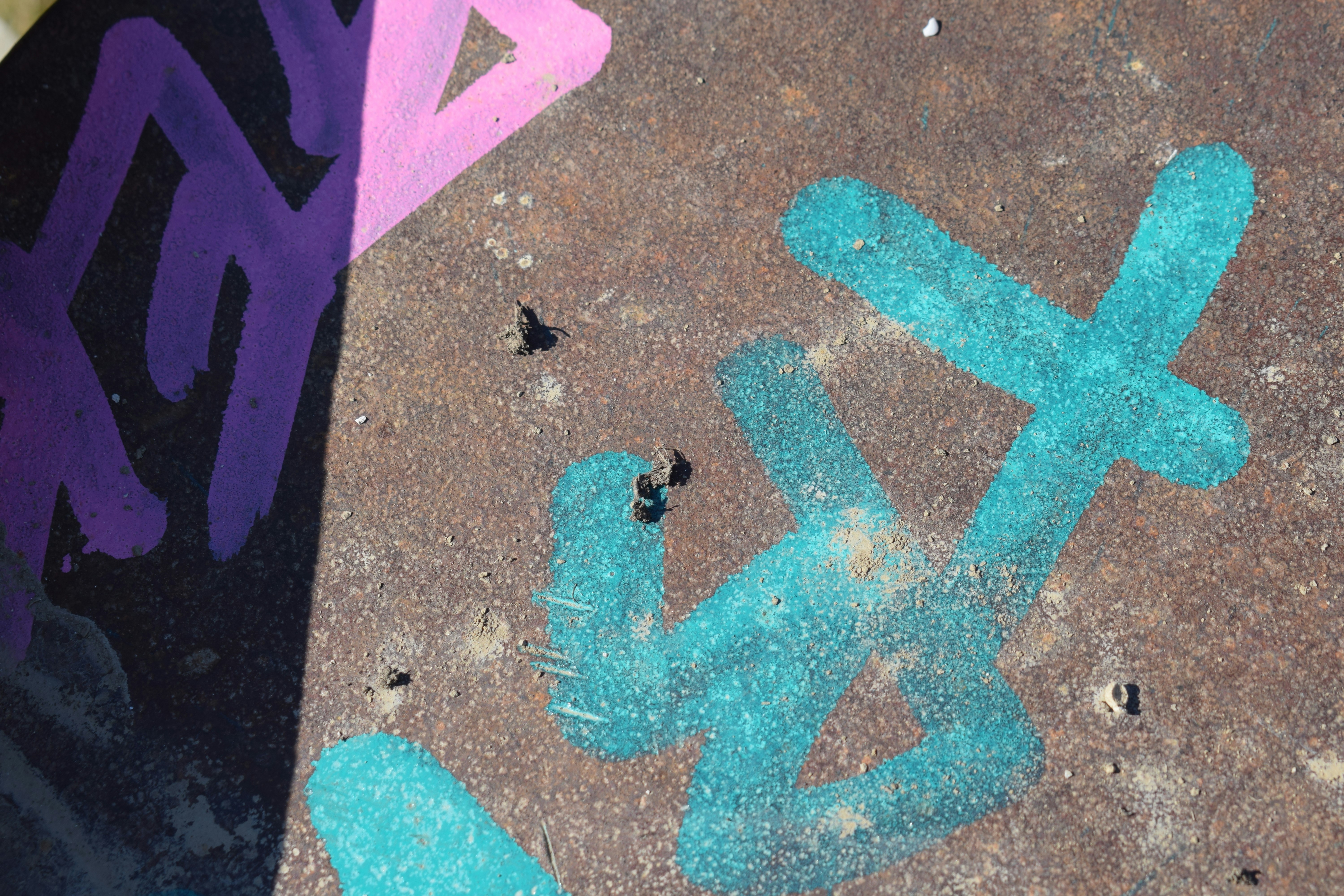 Teal Glyphs on Sun-Warmed Concrete