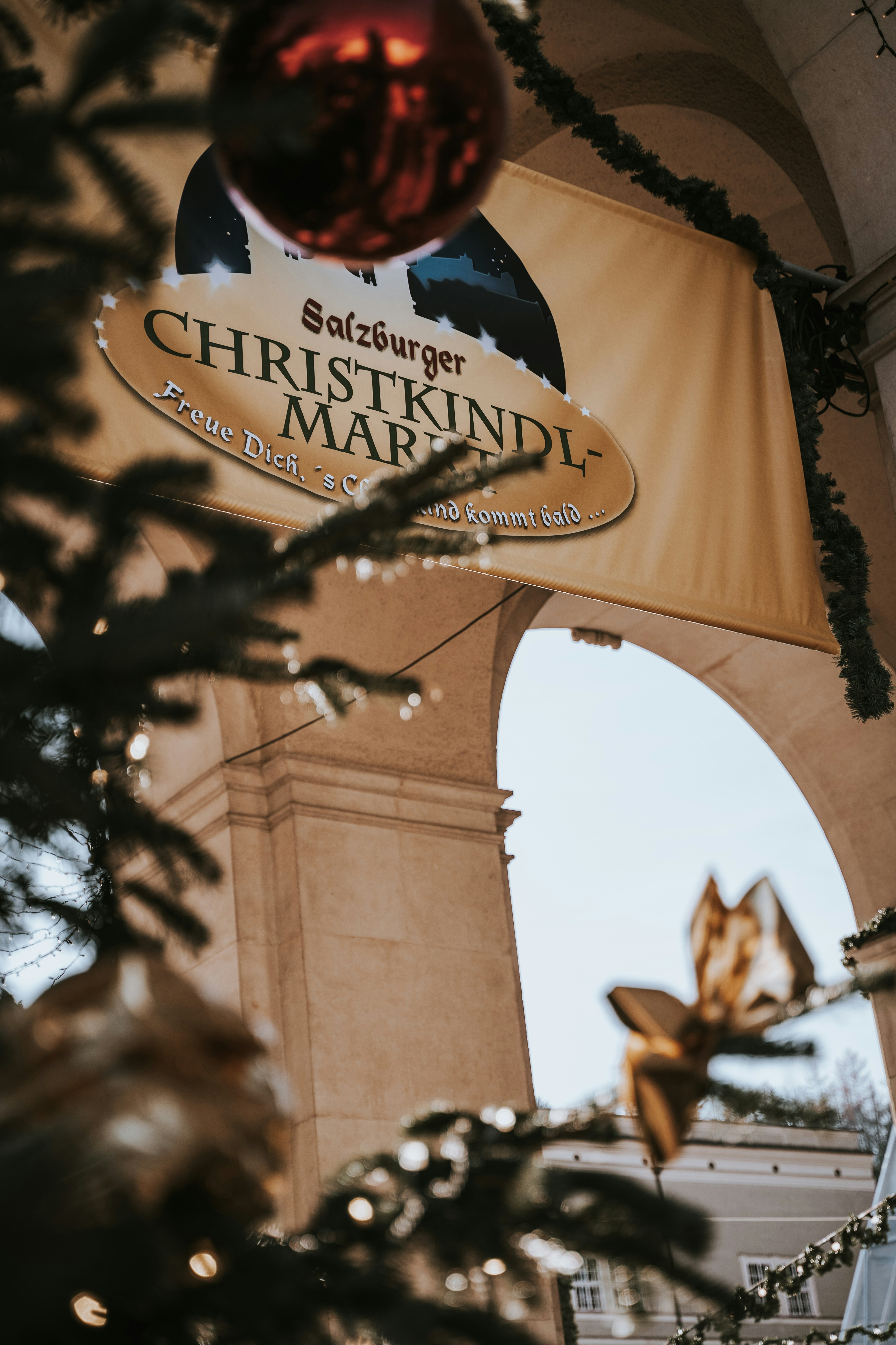 Under the Archway: Festive Banner Framed by Christmas Greens at Salzburger Christkindlmarkt