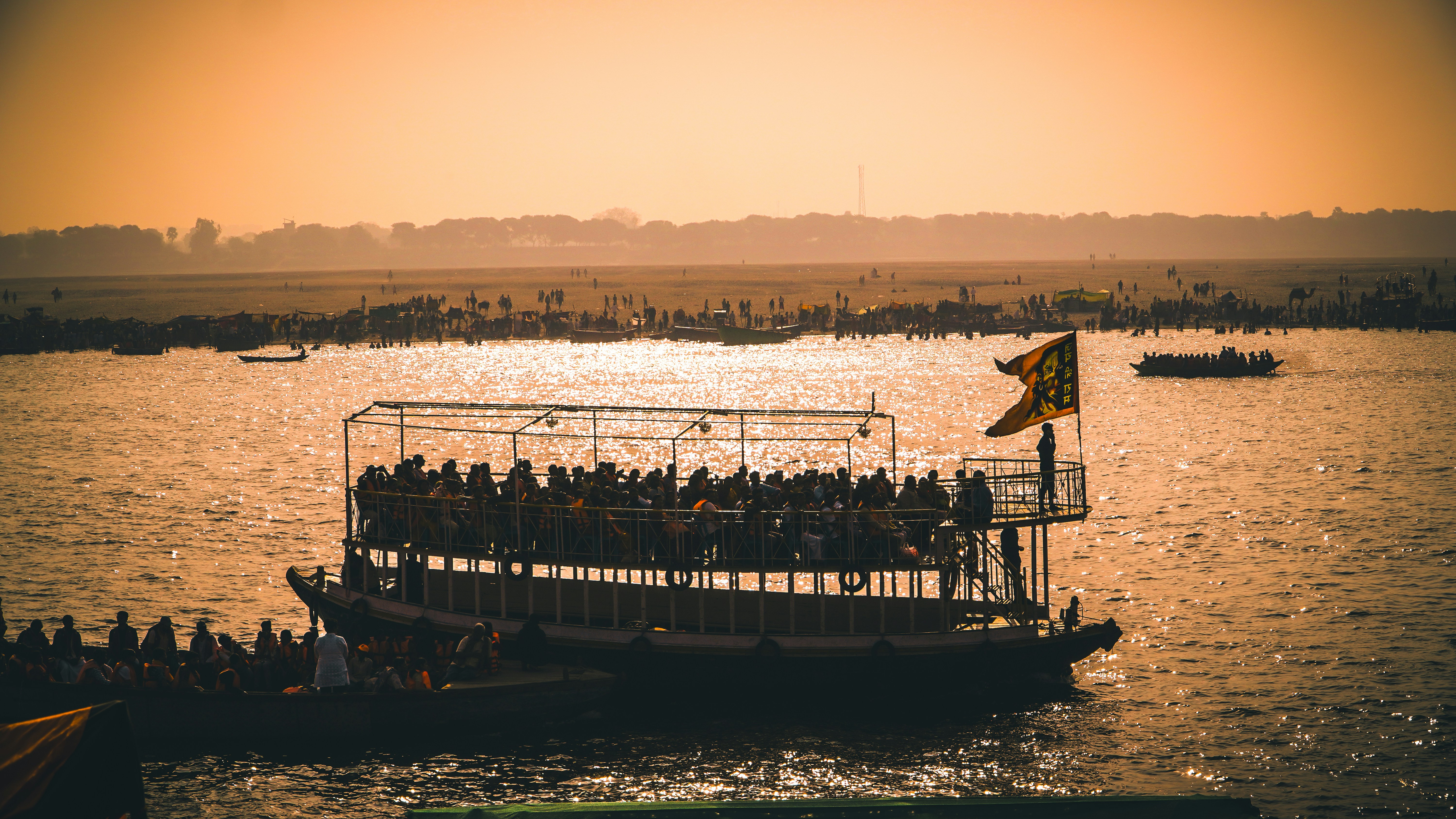 Golden Hour Caravan: A Passenger Boat Silhouetted on Golden Waters