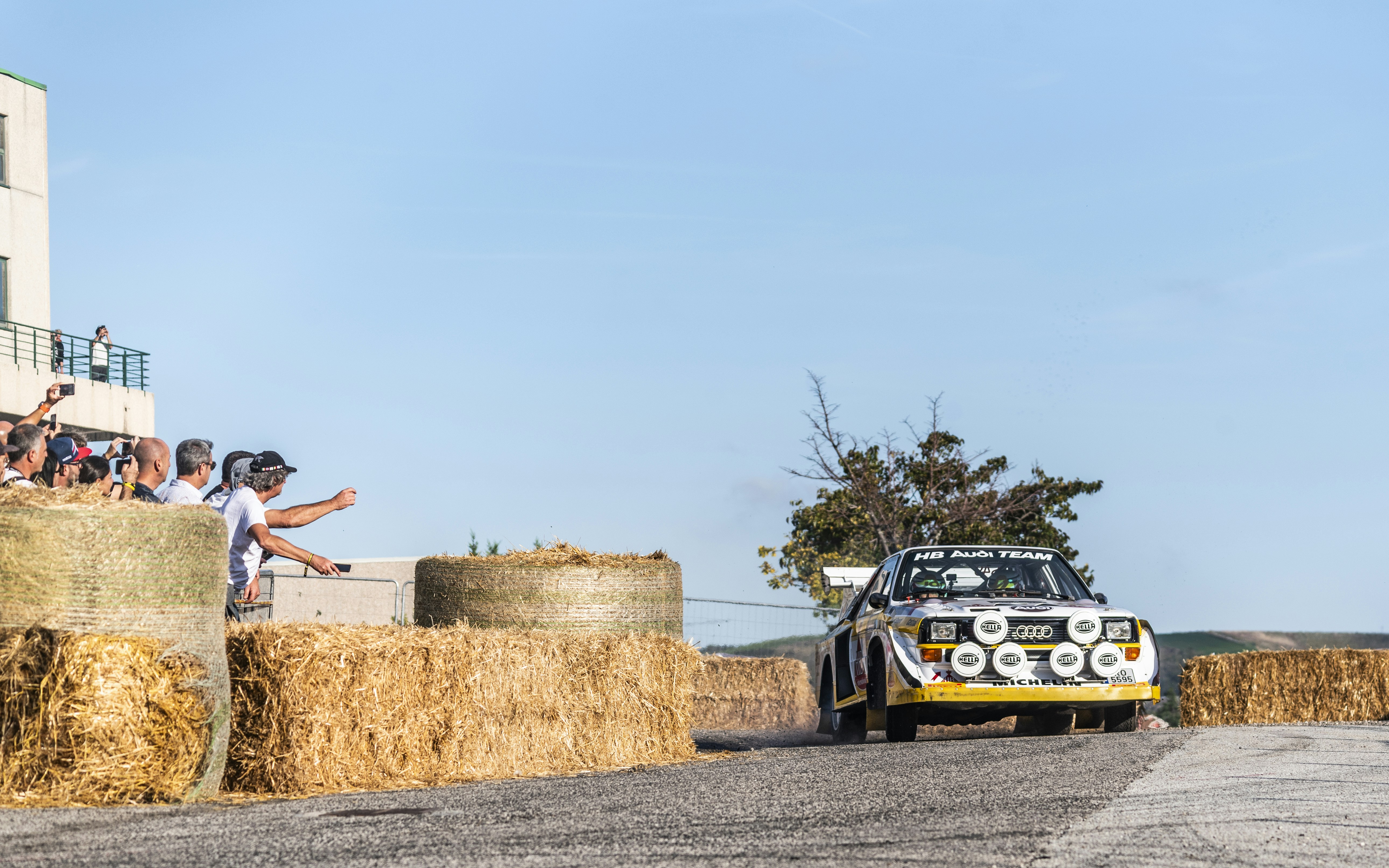 Race car speeds past hay bales on a track. photo – Free Car Image on ...