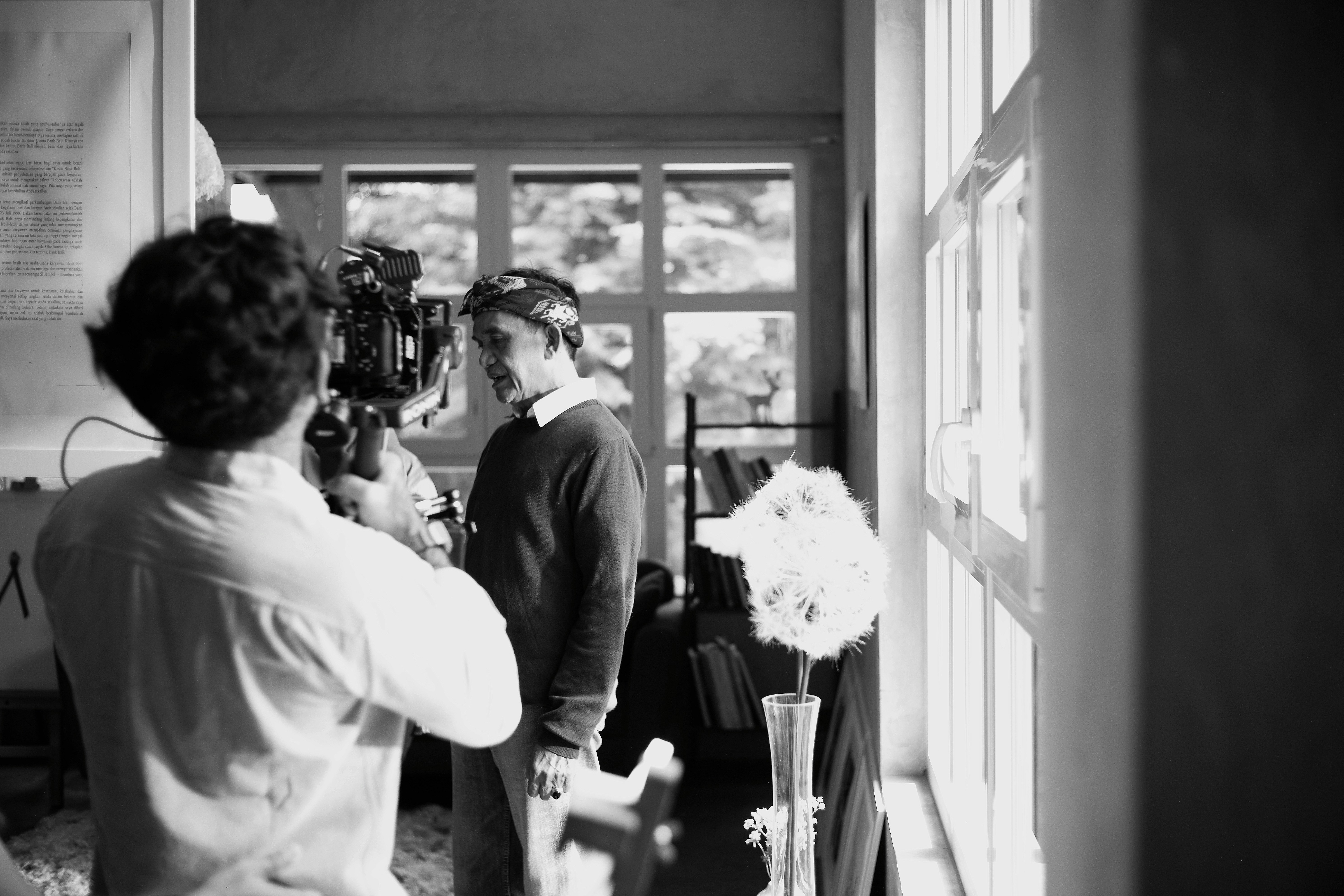 A filmmaker filming a man indoors with sunlight. photo – Free Image on ...
