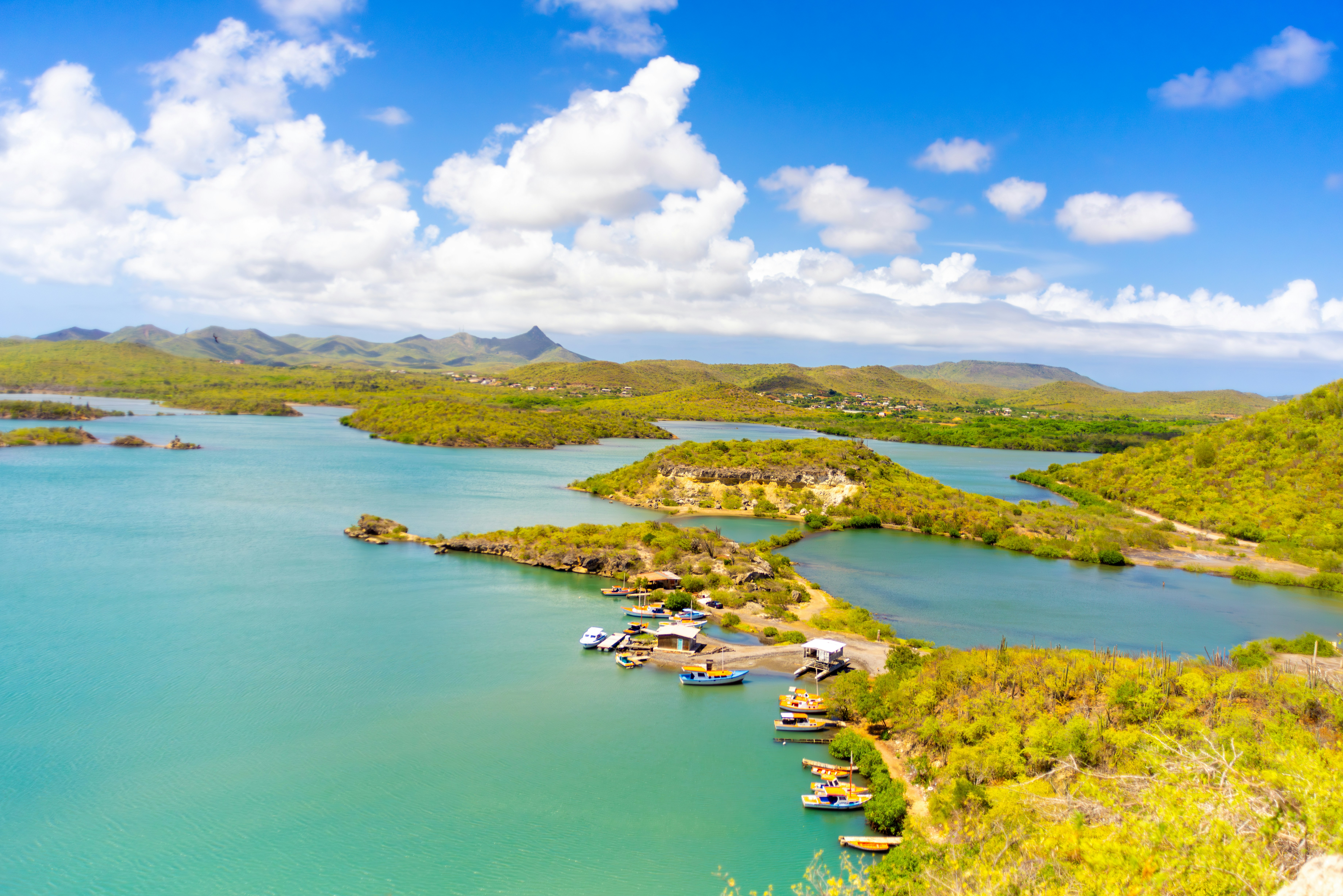 Turquoise waters surround lush green islands under a vibrant blue sky.