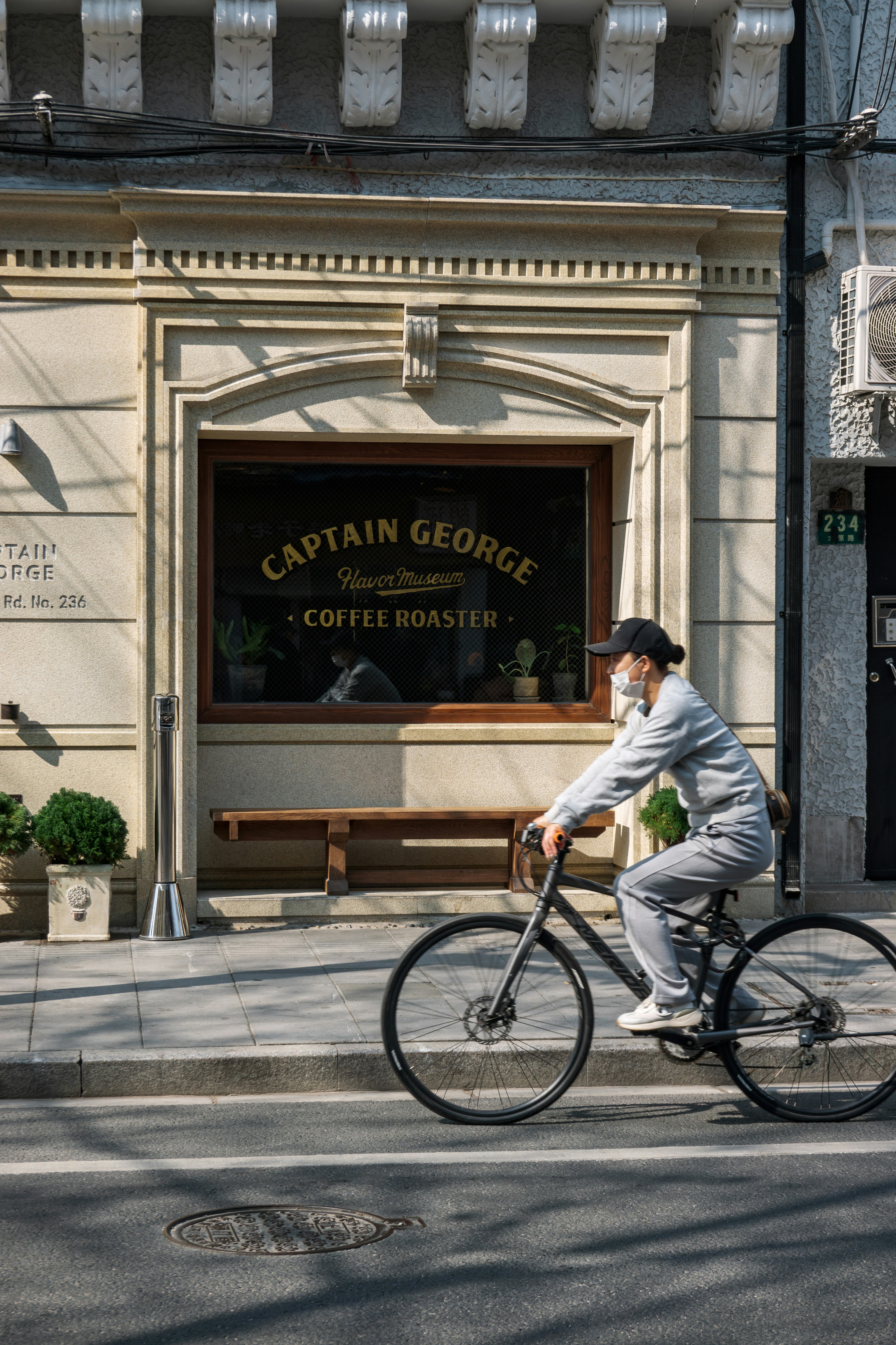 A cyclist rides past a cafe with a unique facade. photo – Free Man ...