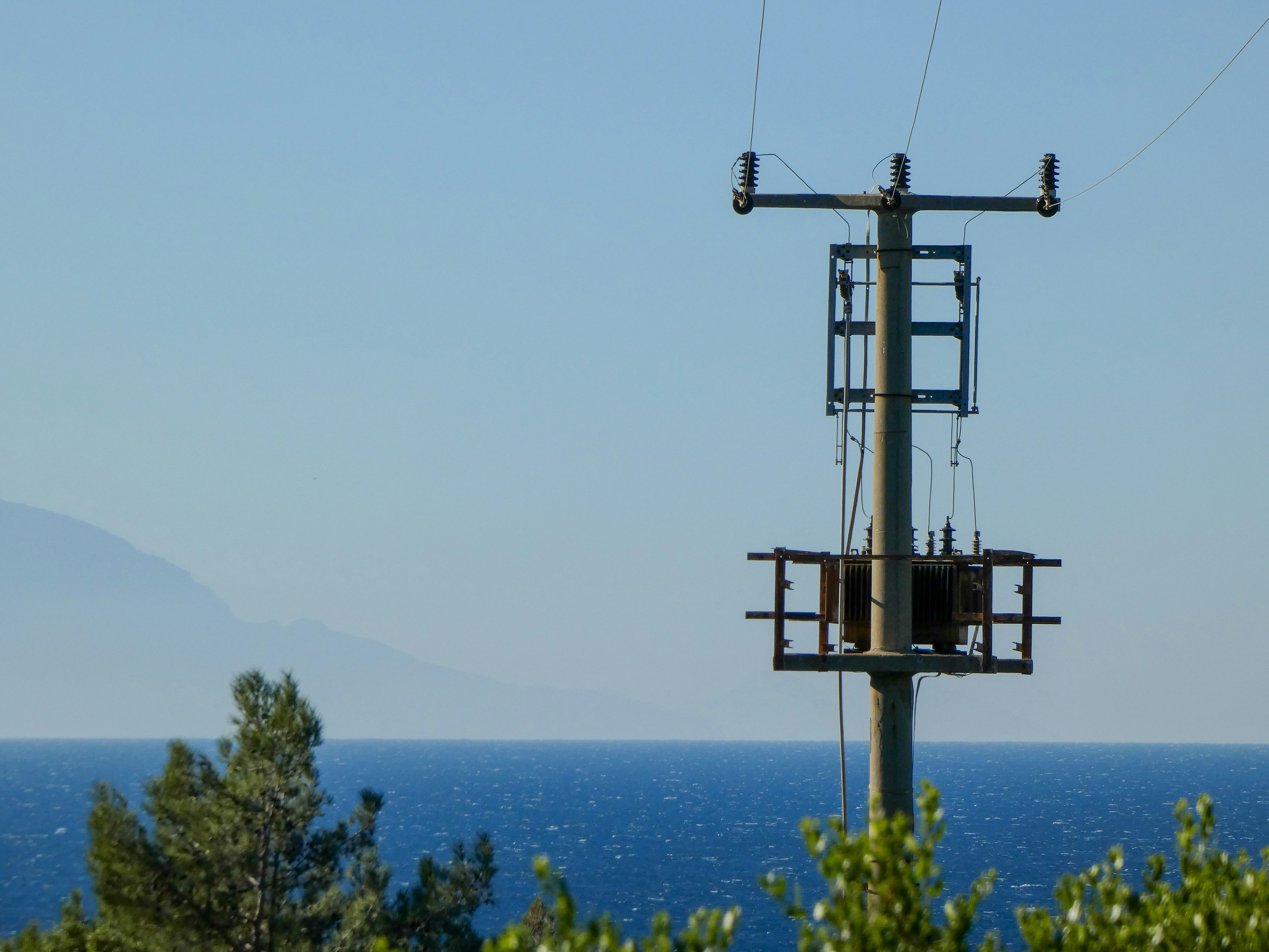 Power pole towers over water and hills. photo – Free Electric Image on ...