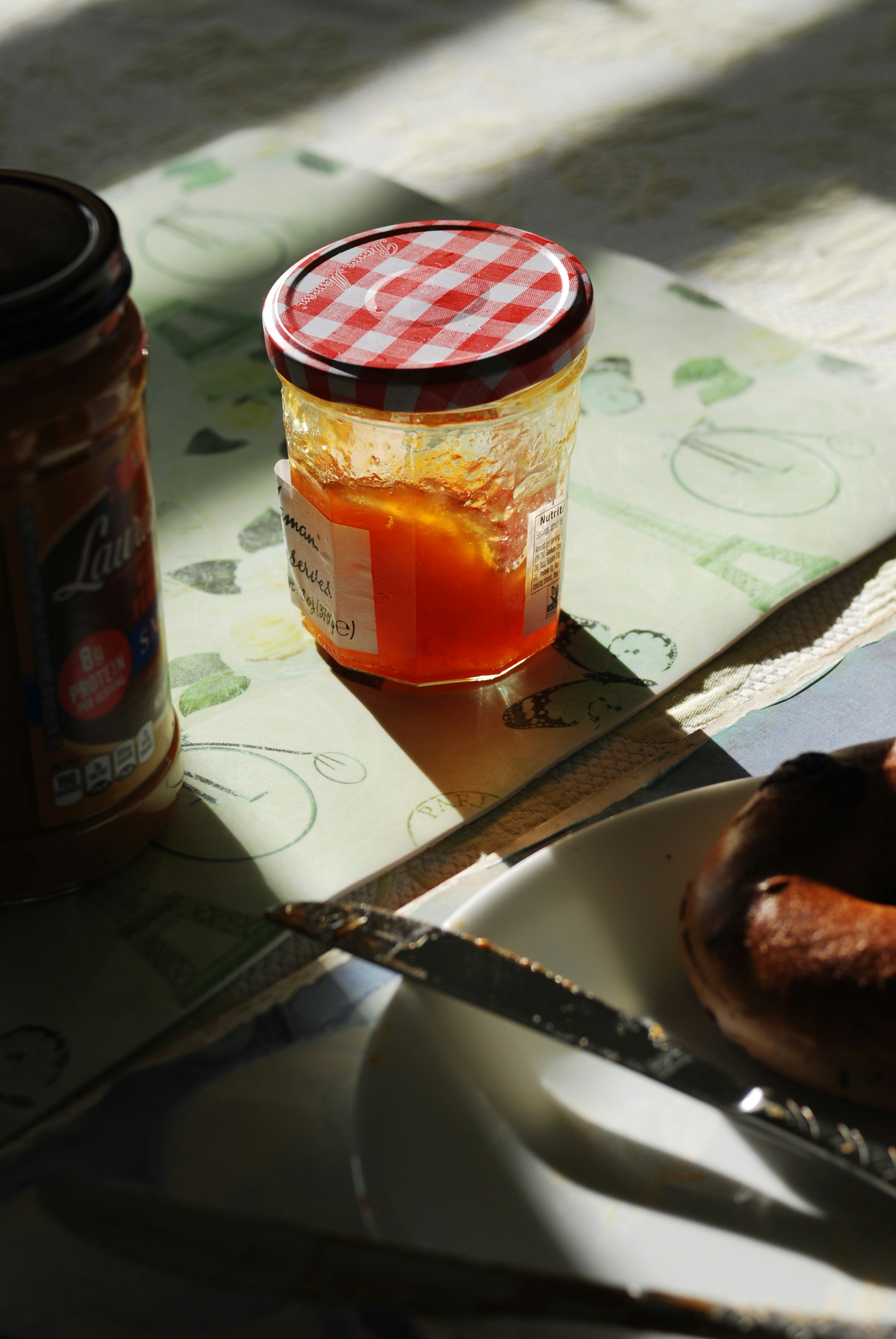 Sunlit Jar of Orange Marmalade: A Quiet Morning Moment on a Patterned Table