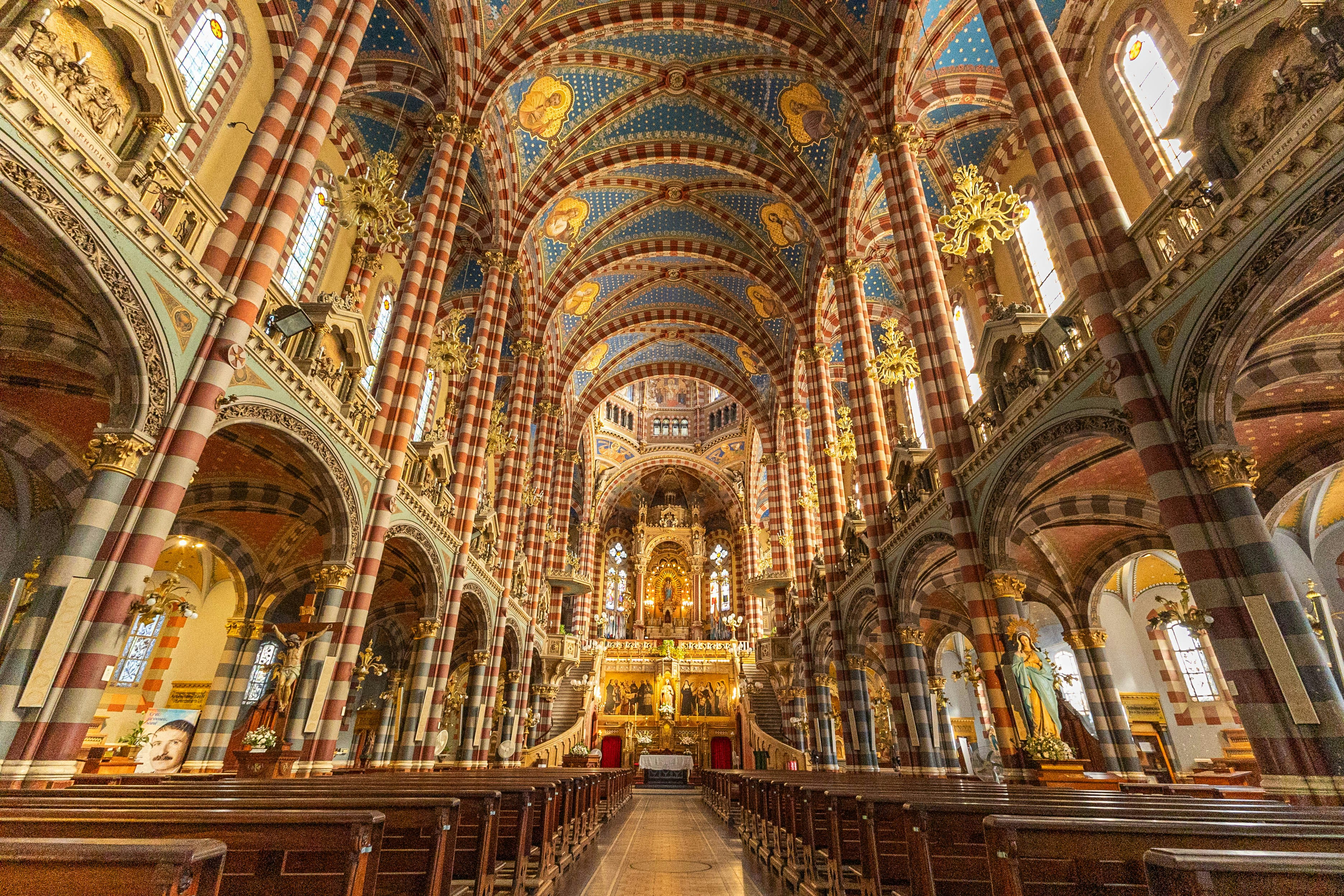 Intricate arches and vibrant patterns adorn the interior of a richly decorated basilica.