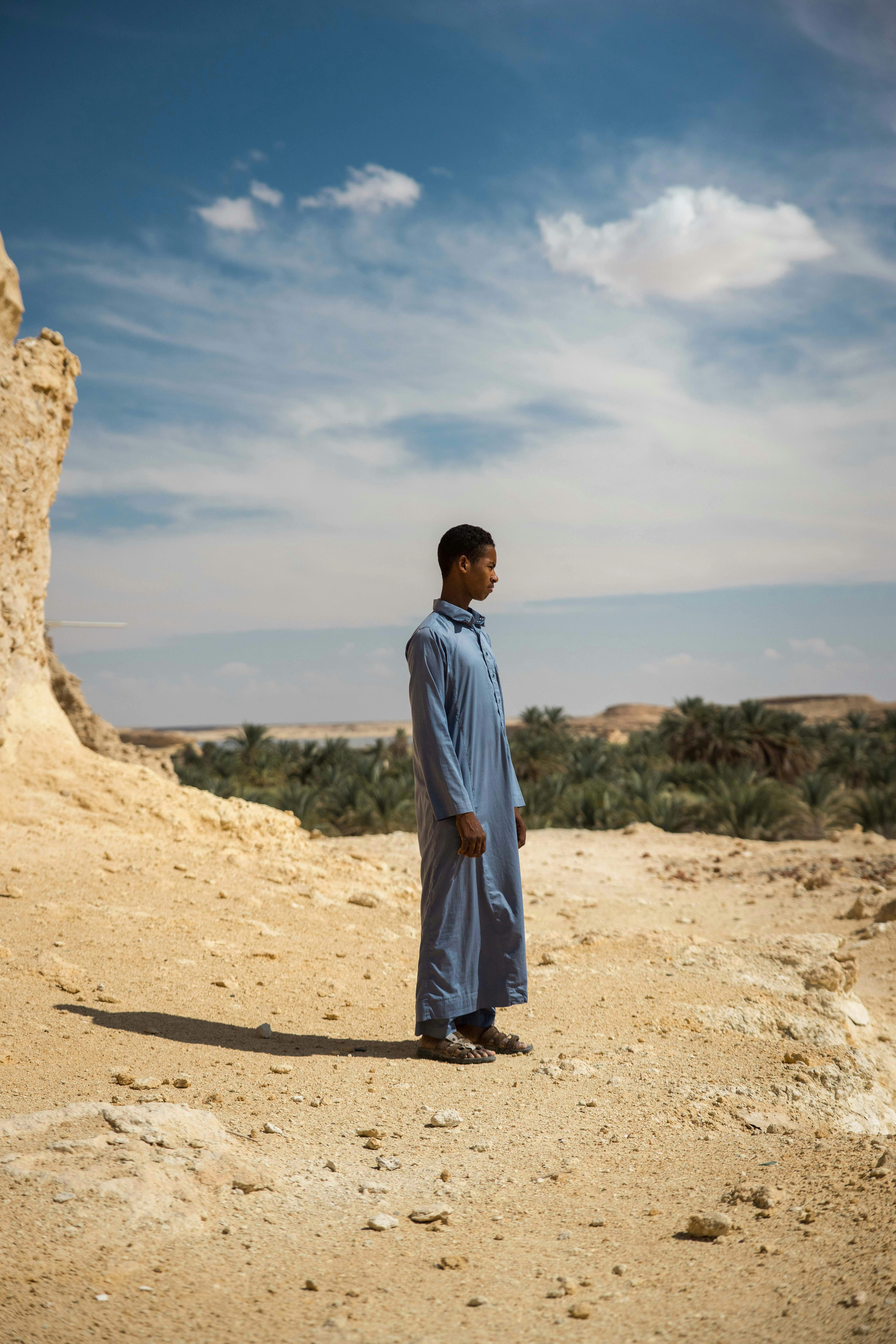 Solitary Figure in Desert Light: A Quiet Portrait Against a Stone Outcrop