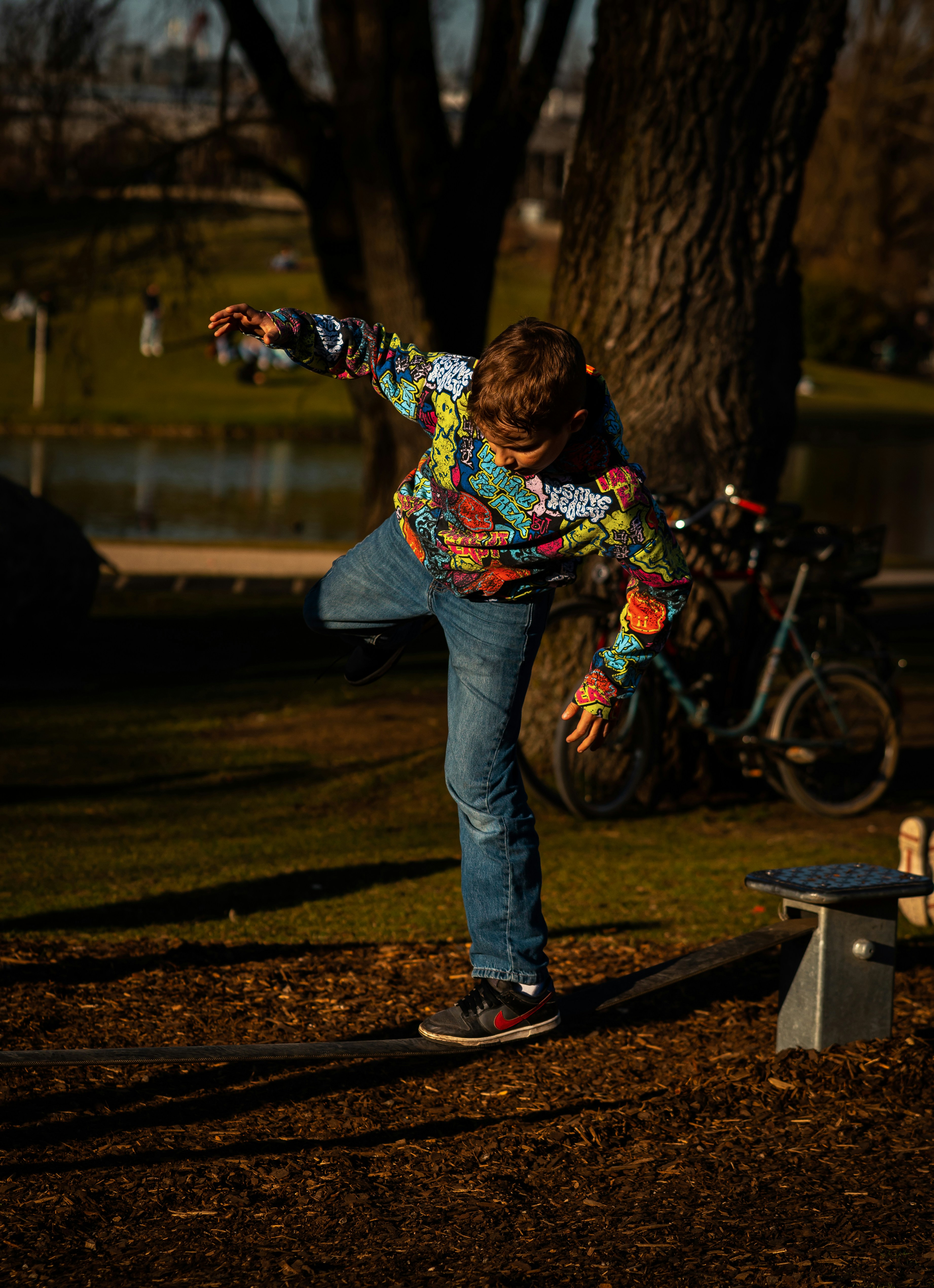 Patterned Sweatshirt Acrobat on a Park Beam