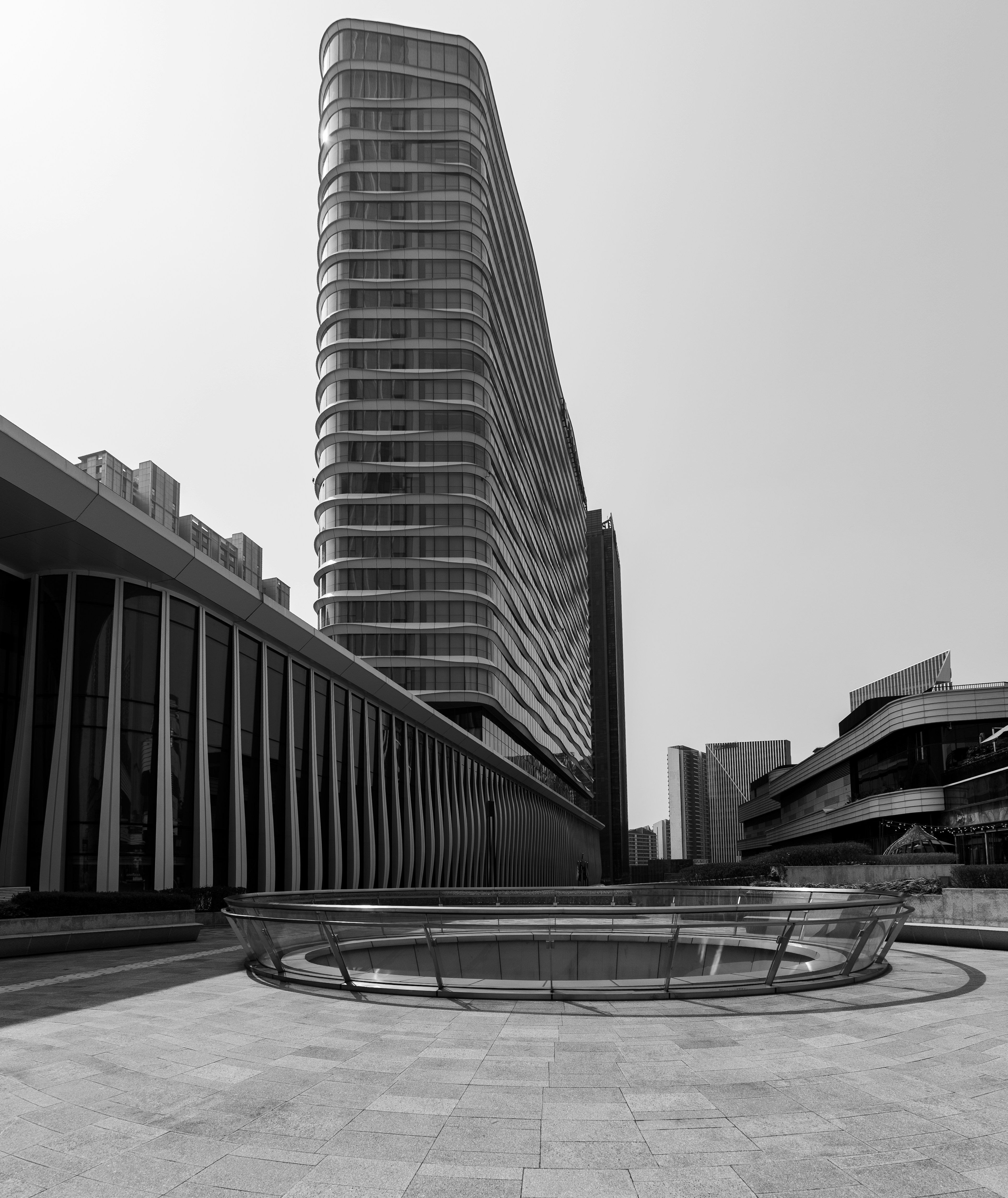Concrete Monument: A Towering Curve Against the City Horizon