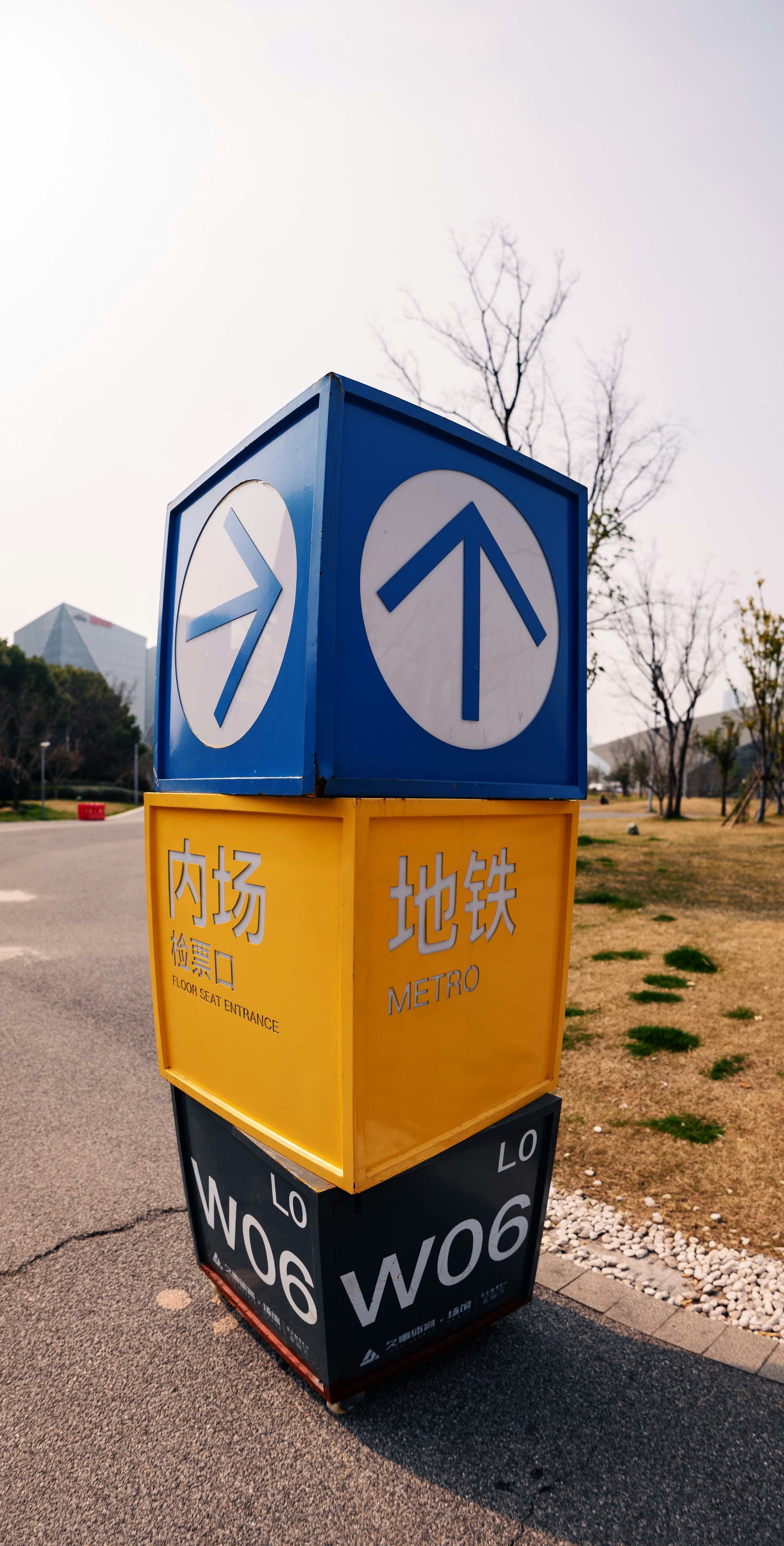 Metro Arrow Tower: A Three-Tier Signpost Framing a Quiet Campus Path