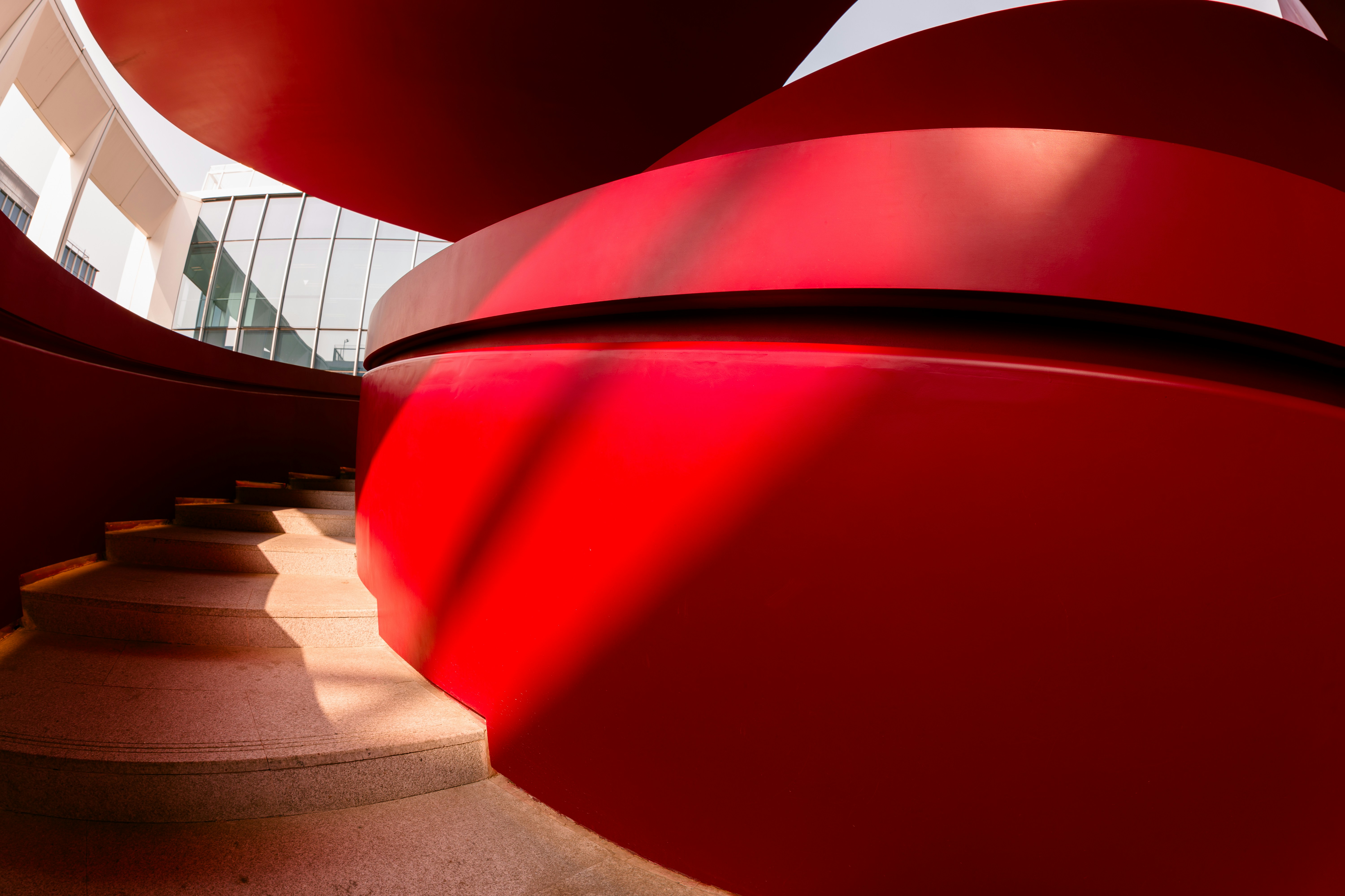 Sunlit Red Arc: Sculptural Curve and Staircase