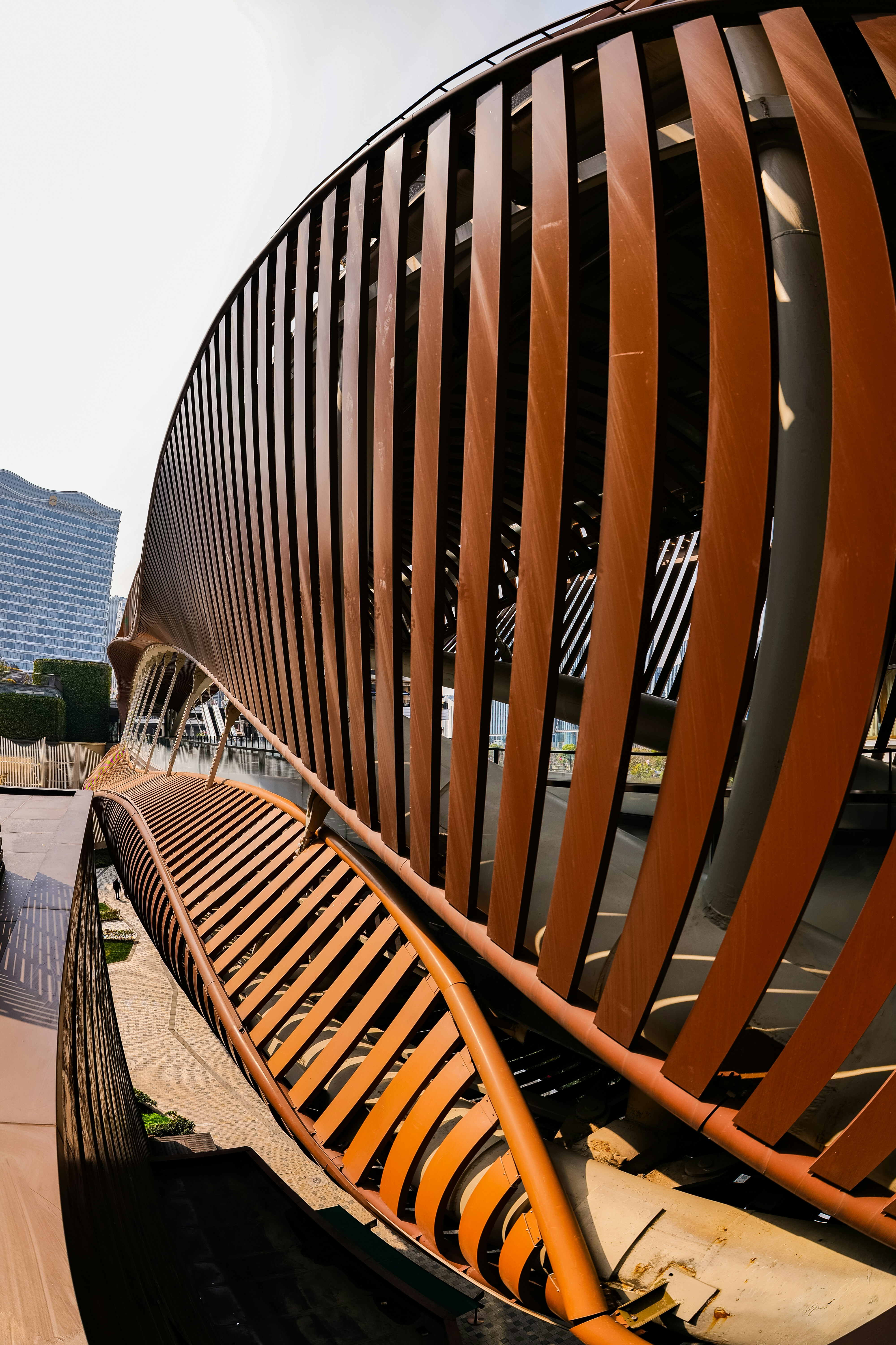 Curved Rust: Striated Metal Ribbons Curling Around a Modern Atrium