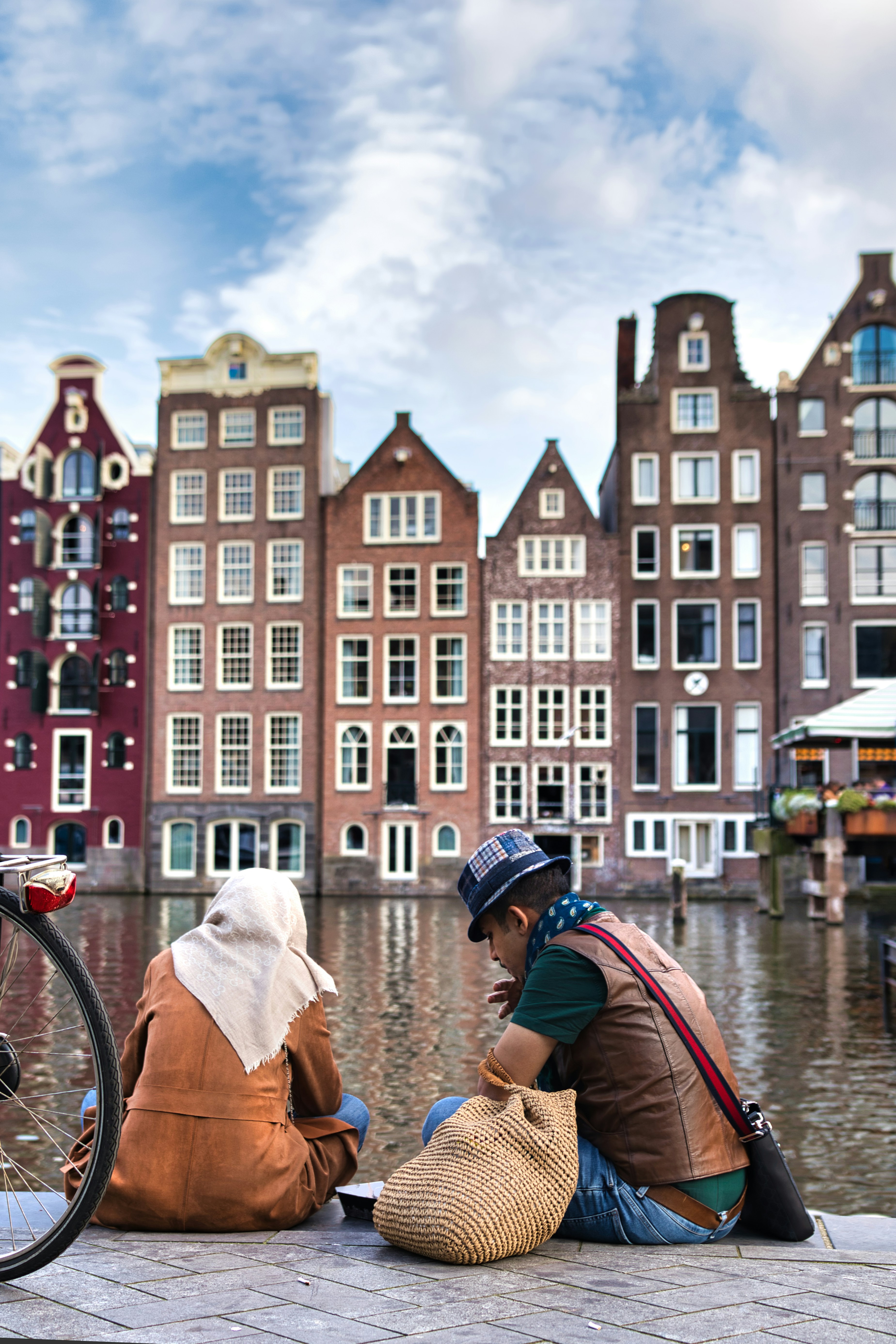 Afternoon by the Amsterdam Canal: Quiet Conversation Among Colorful Gabled Facades