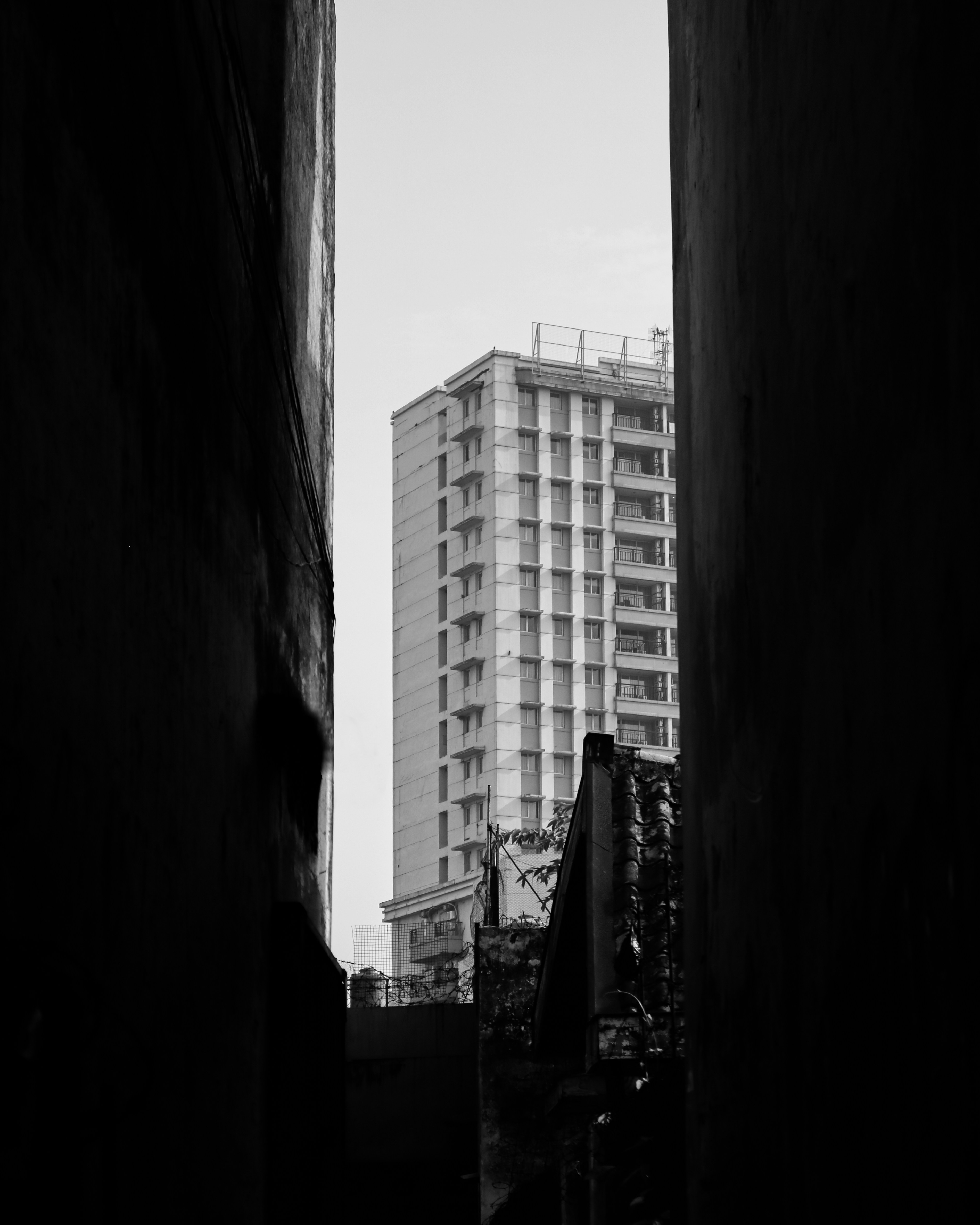 A tall building is seen through narrow spaces. photo – Free Wallpaper ...