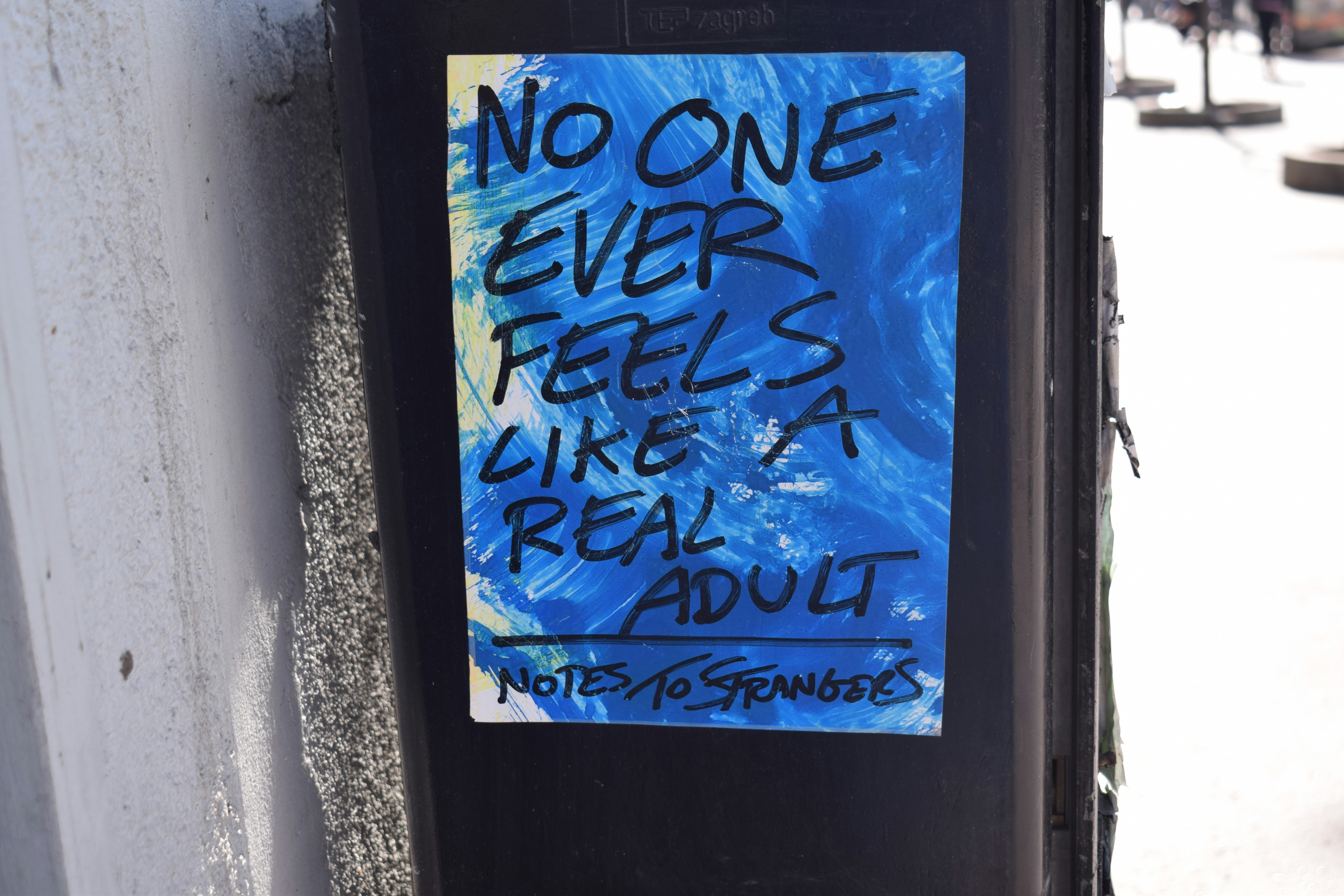 The sign reads: "no one ever feels like a real adult."