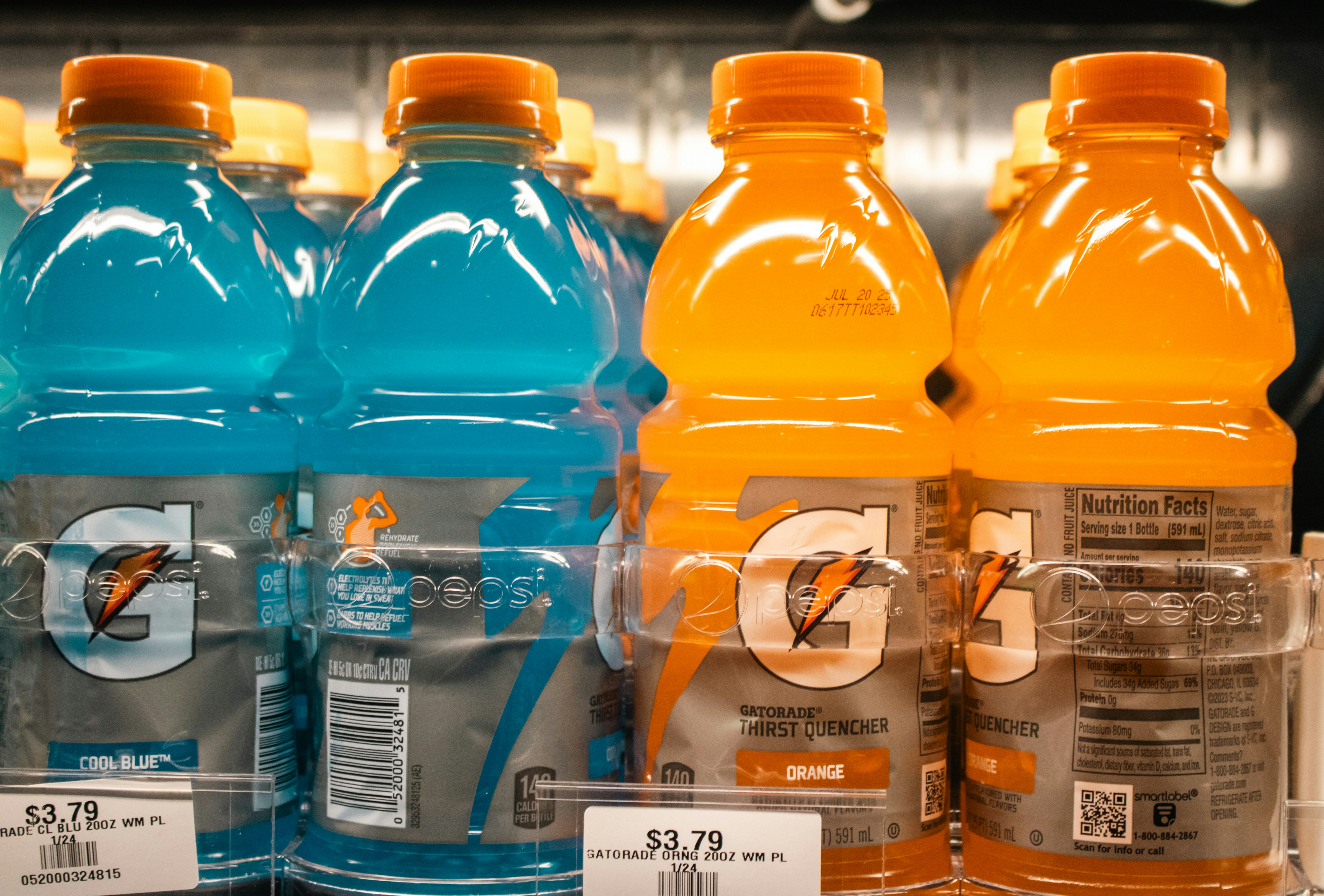 Gatorade bottles are shown on a shelf. photo – Free Blue Image on Unsplash